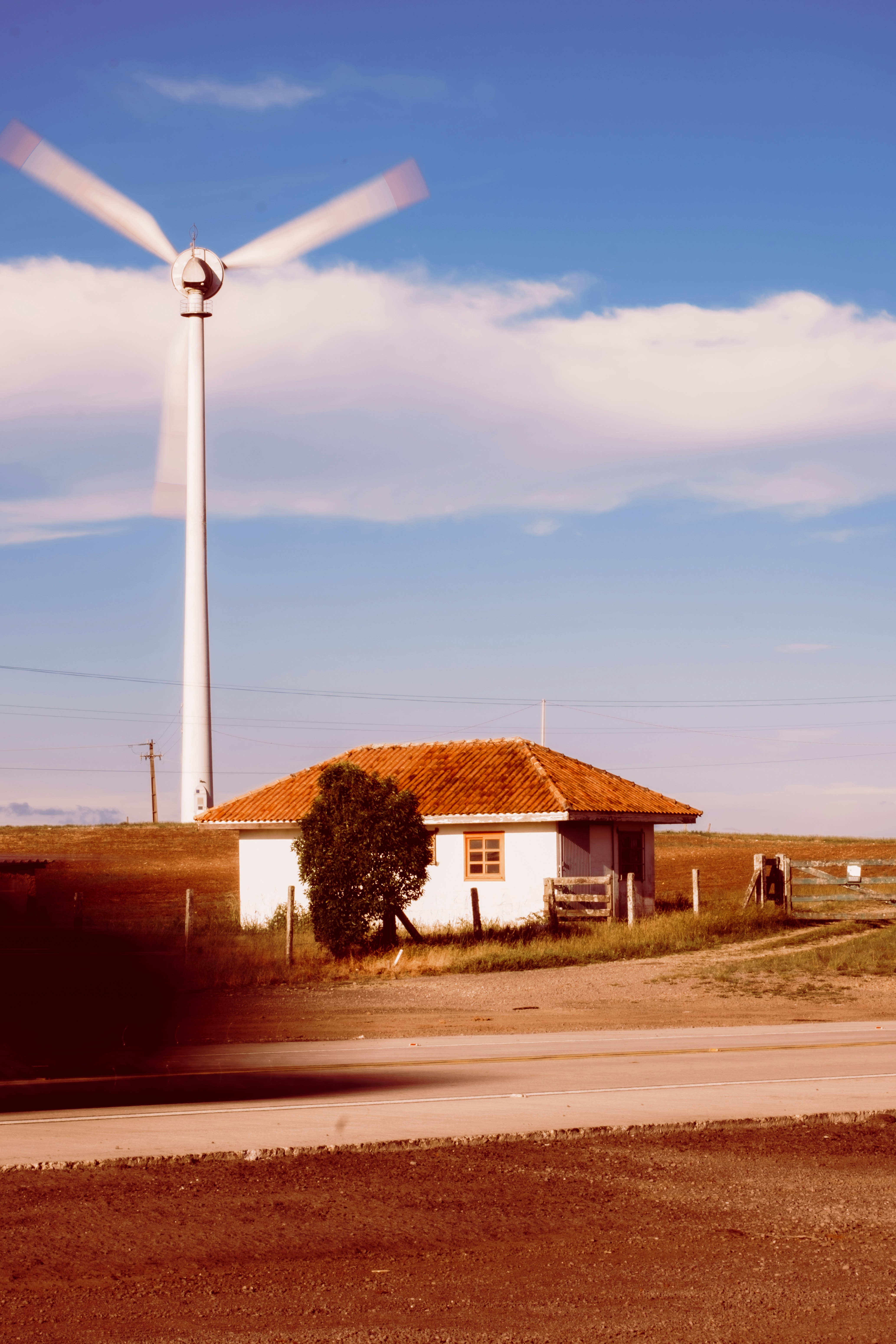 Blades in slow motion over a red-roofed rural house