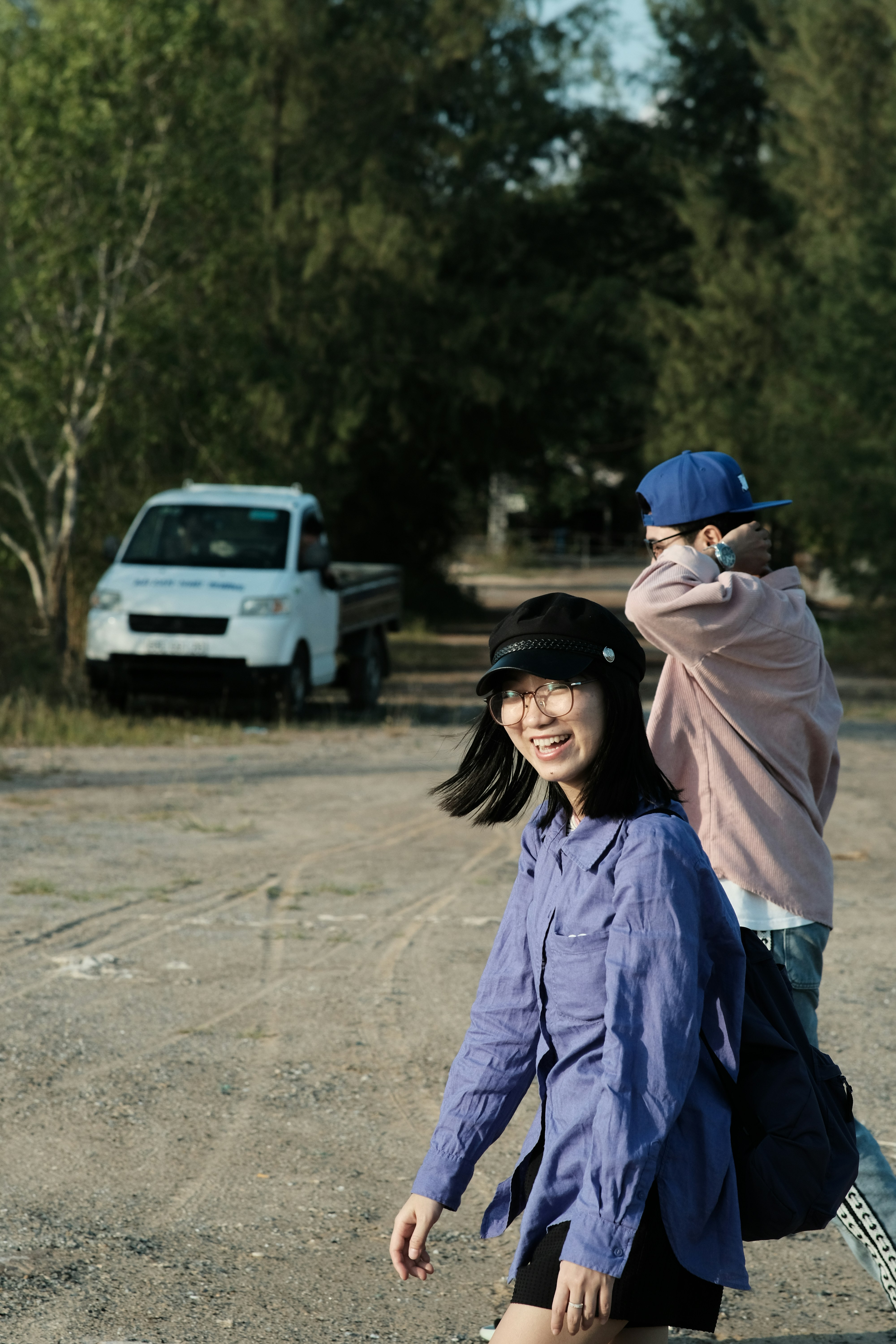 Sunlit Park Stroll: a candid smile in a casual gravel lot