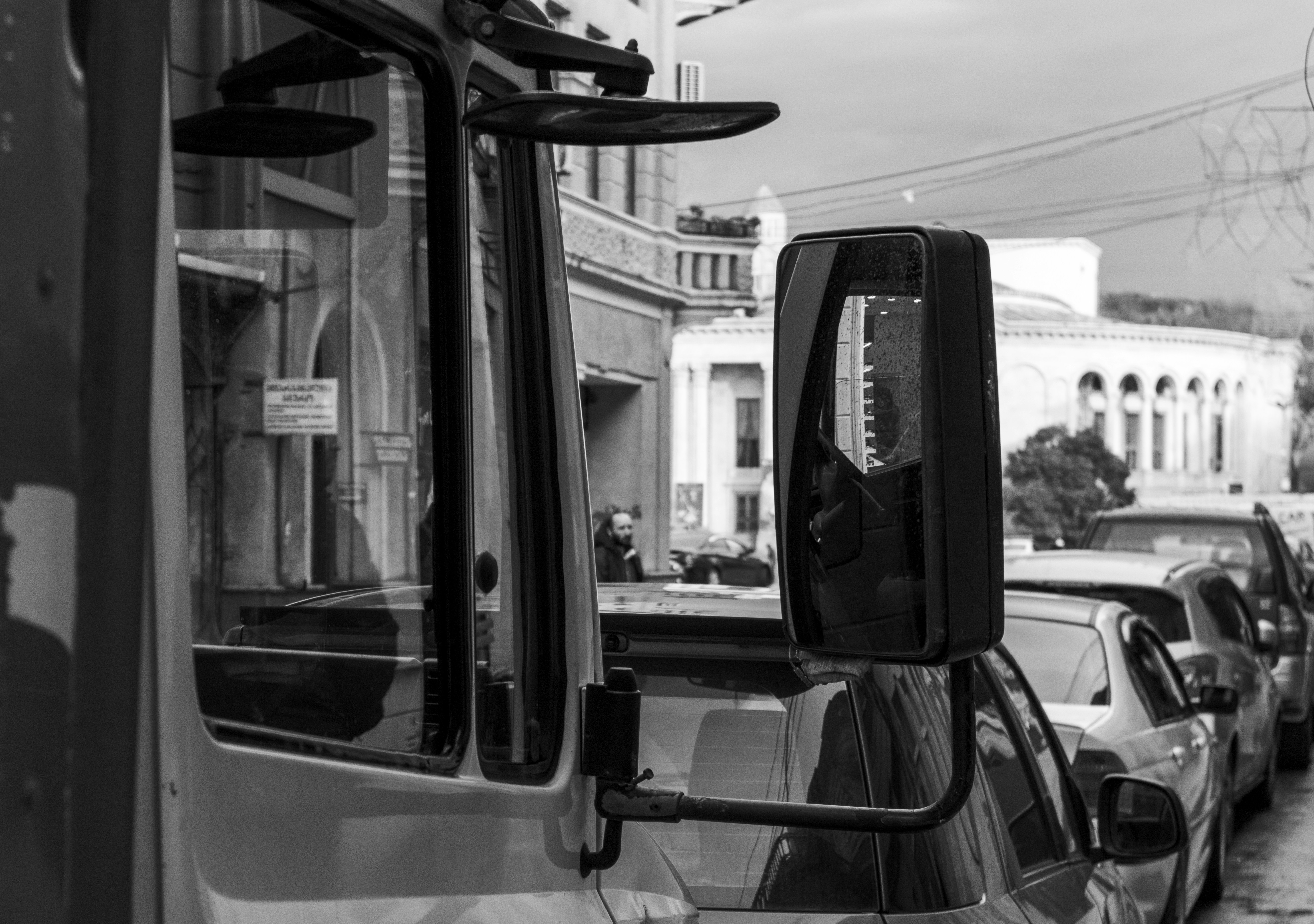 Monochrome Street Tableau: a Bus, its Mirror, and Quiet Traffic