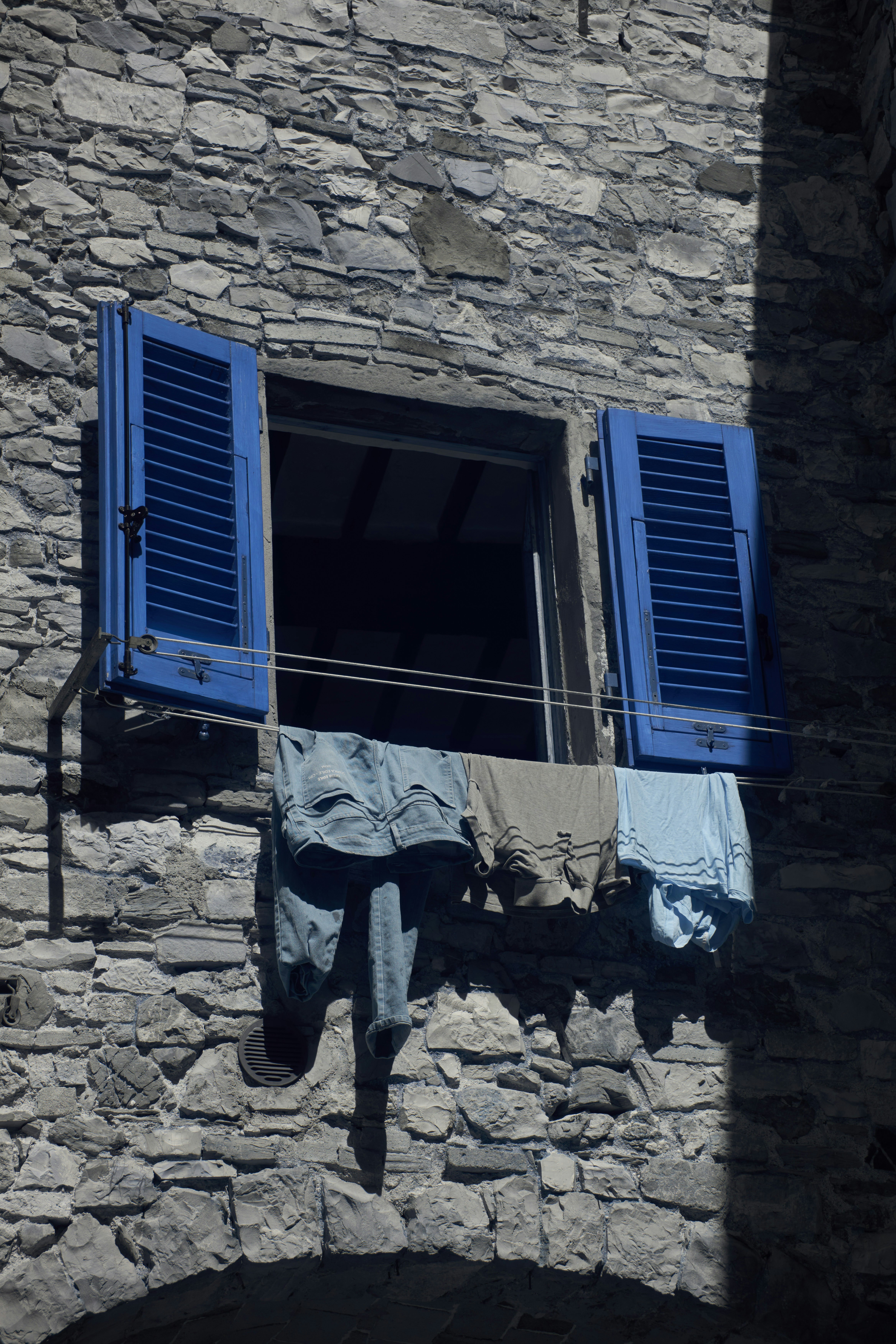 Blue Shuttered Window with Laundry Outpost