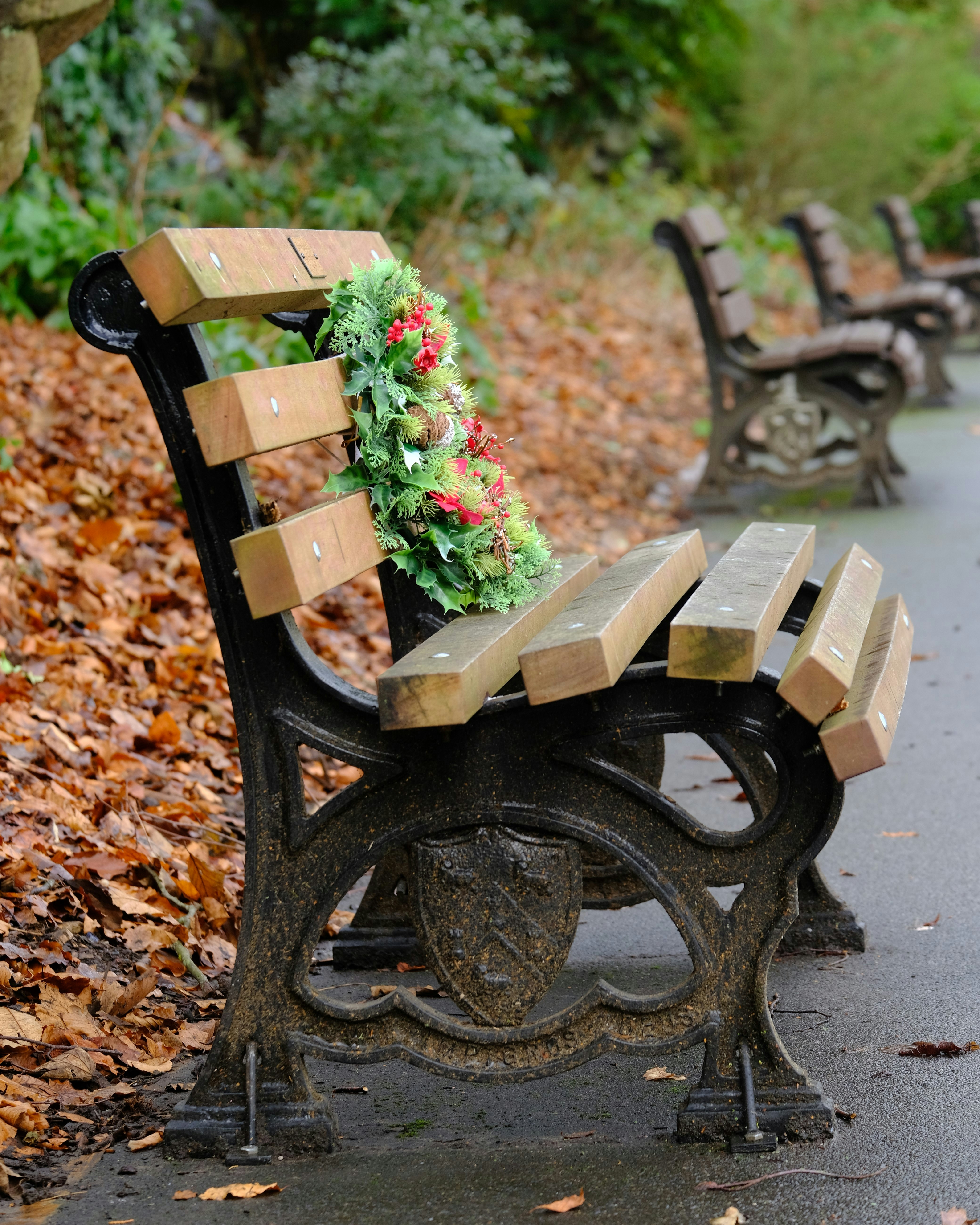Bouquet on a Weathered Park Bench: Greenery and Pink Blooms Amid Autumn Leaves
