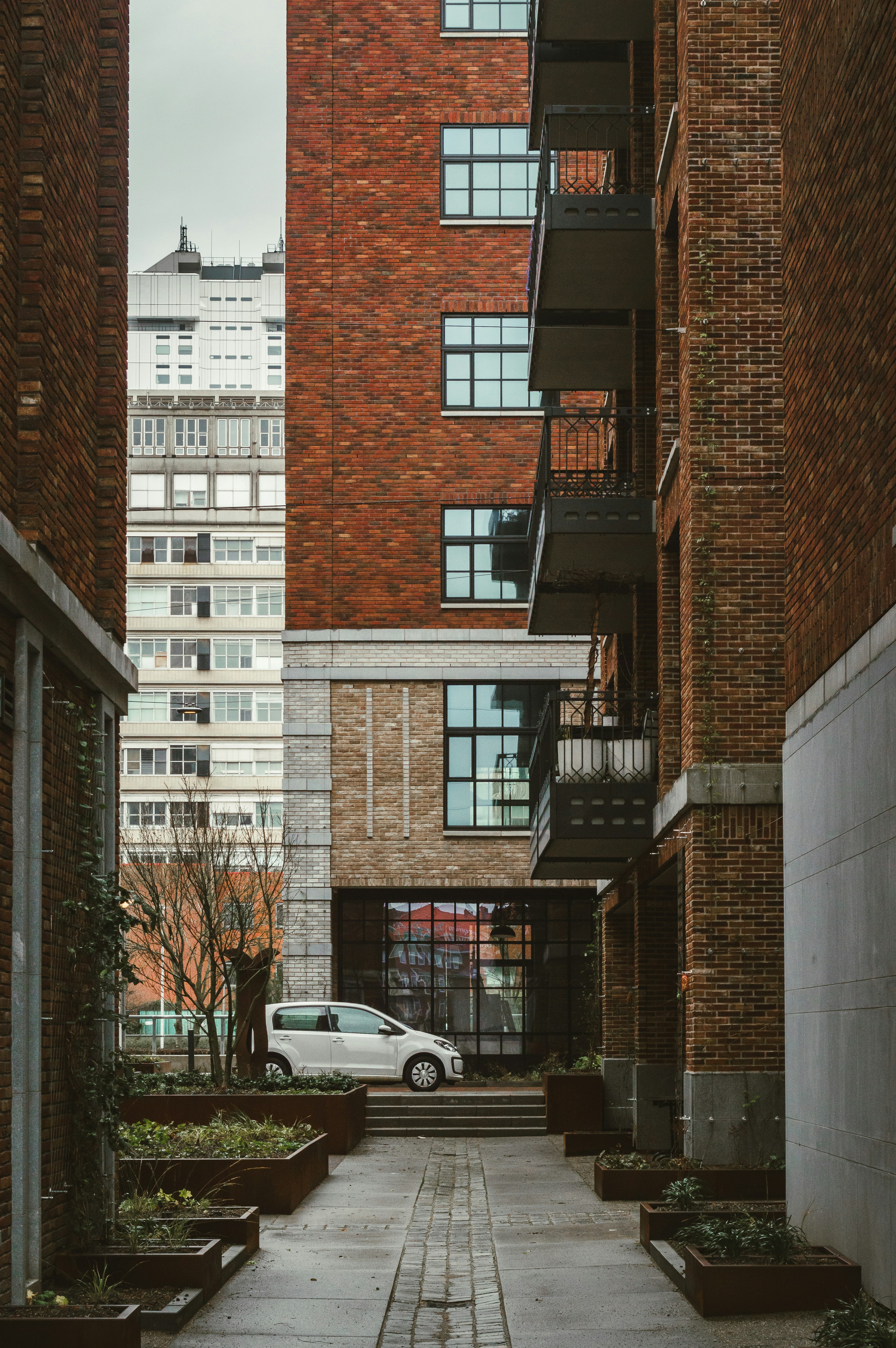 A car is parked in a courtyard between two buildings photo – Free ...