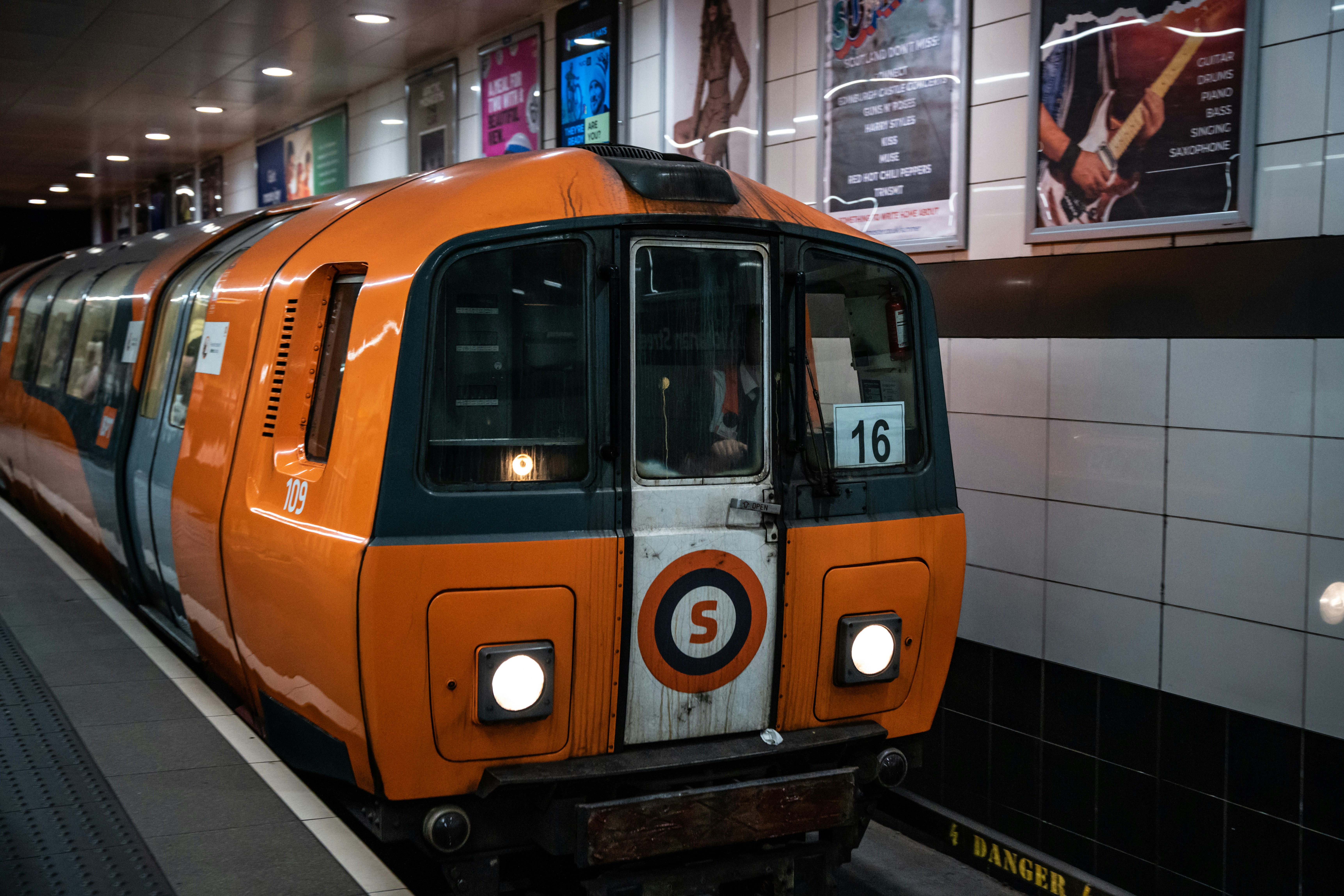 An orange train pulling into a train station photo – Free Glasgow Image ...