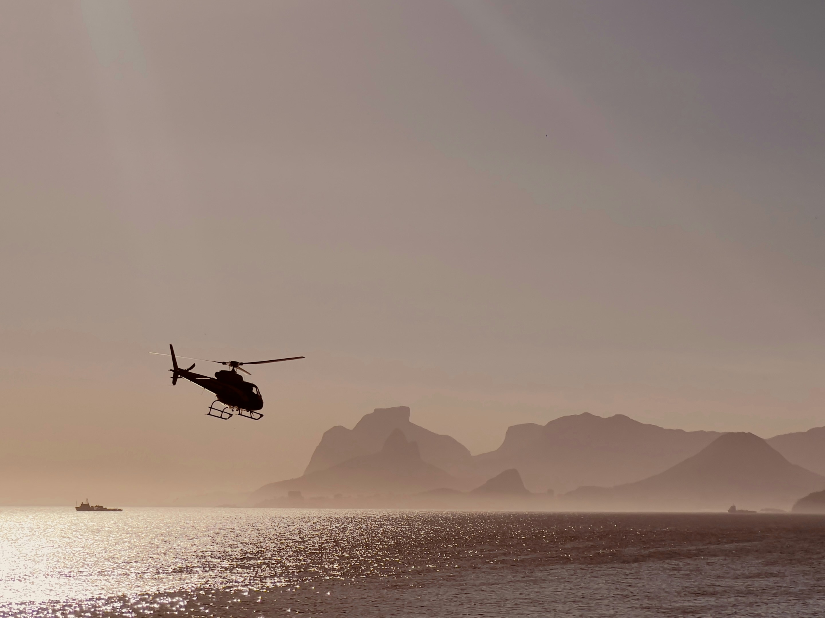 Helicopter Silhouette at Sunset Over Tranquil Waters