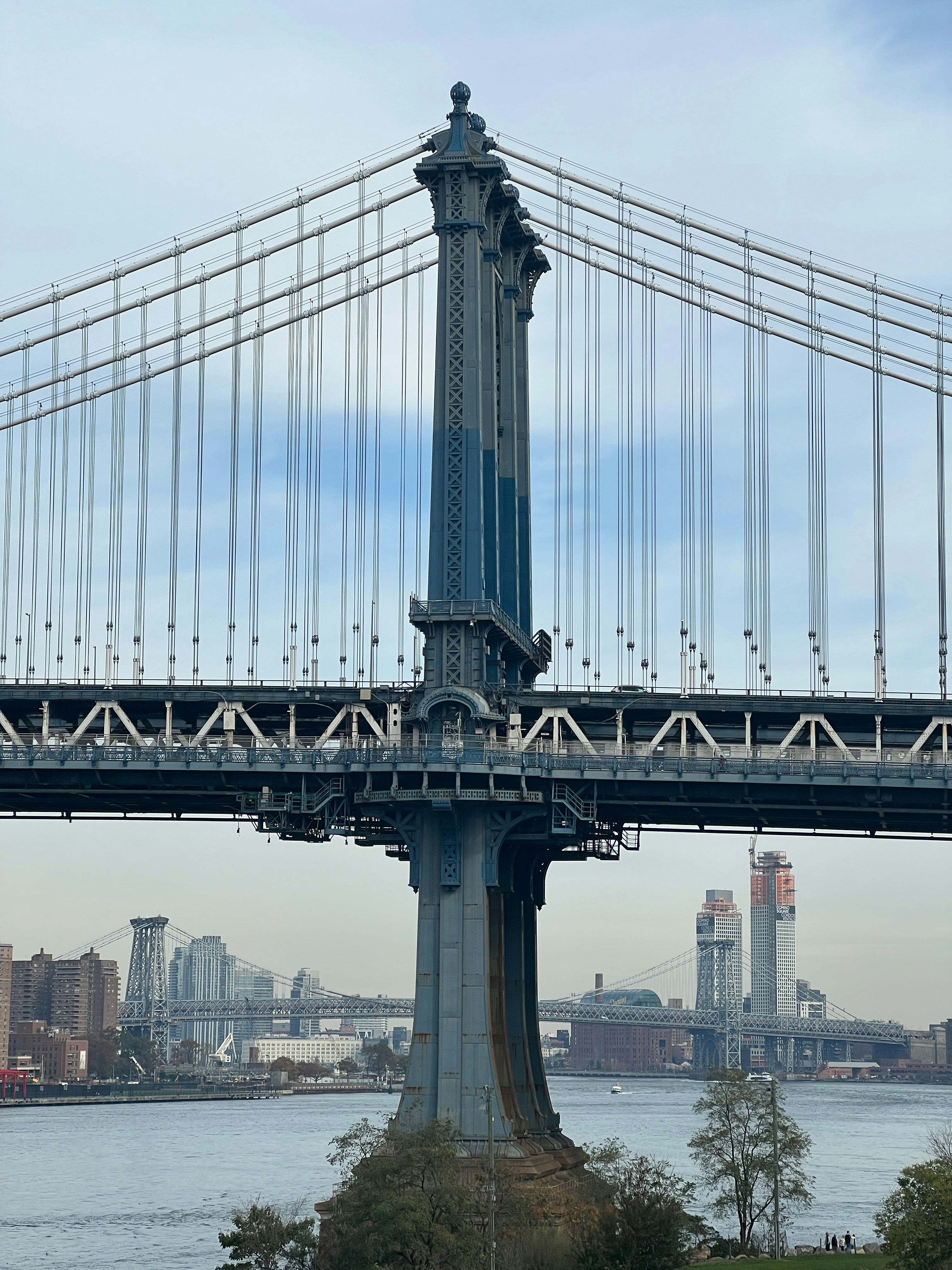 Iron Sentinel Over the East River: a blue-tinted suspension tower framing the city skyline