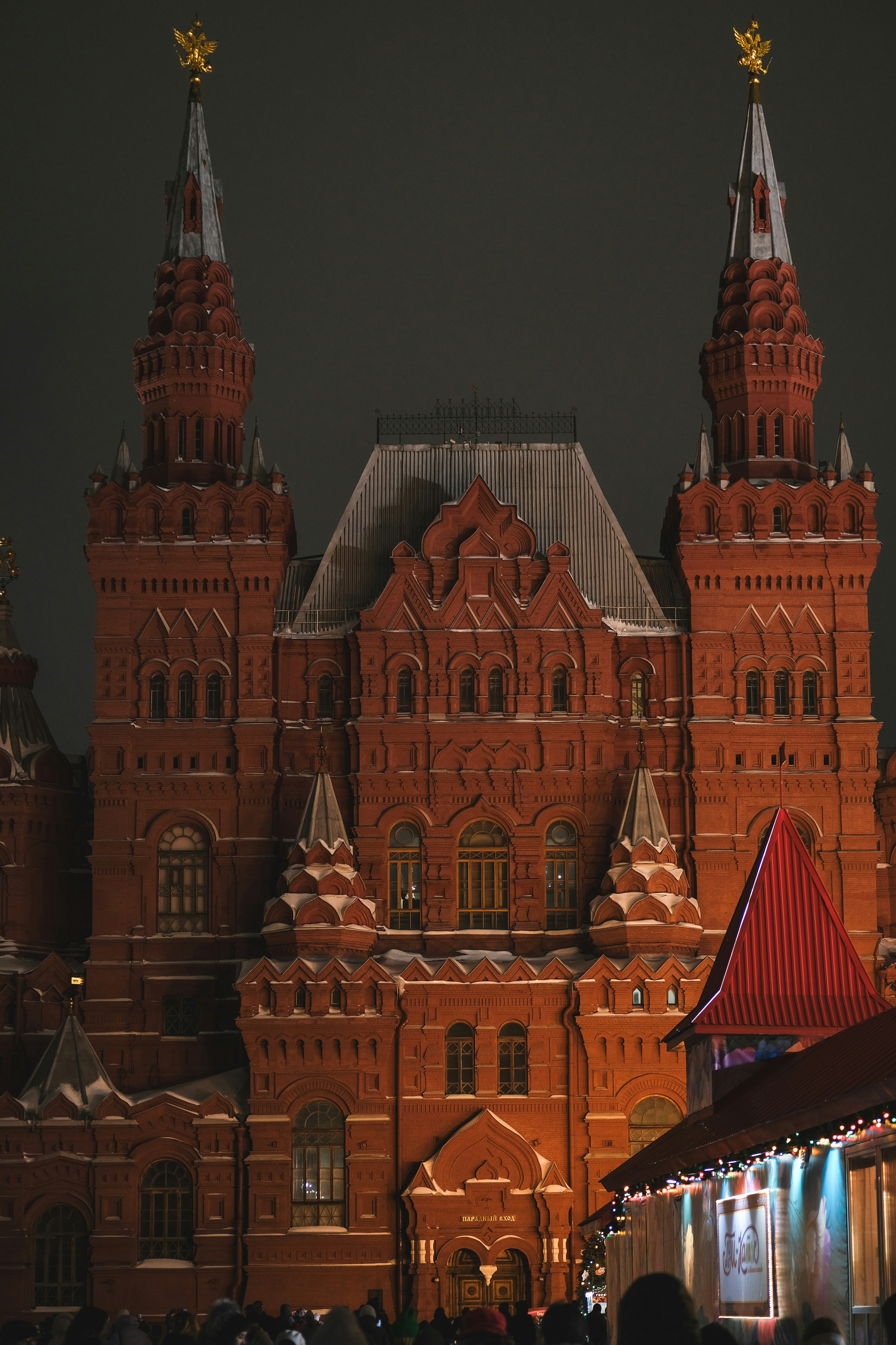 Nocturnal Fortress: Market Lights Framing a Red-Brick Palace