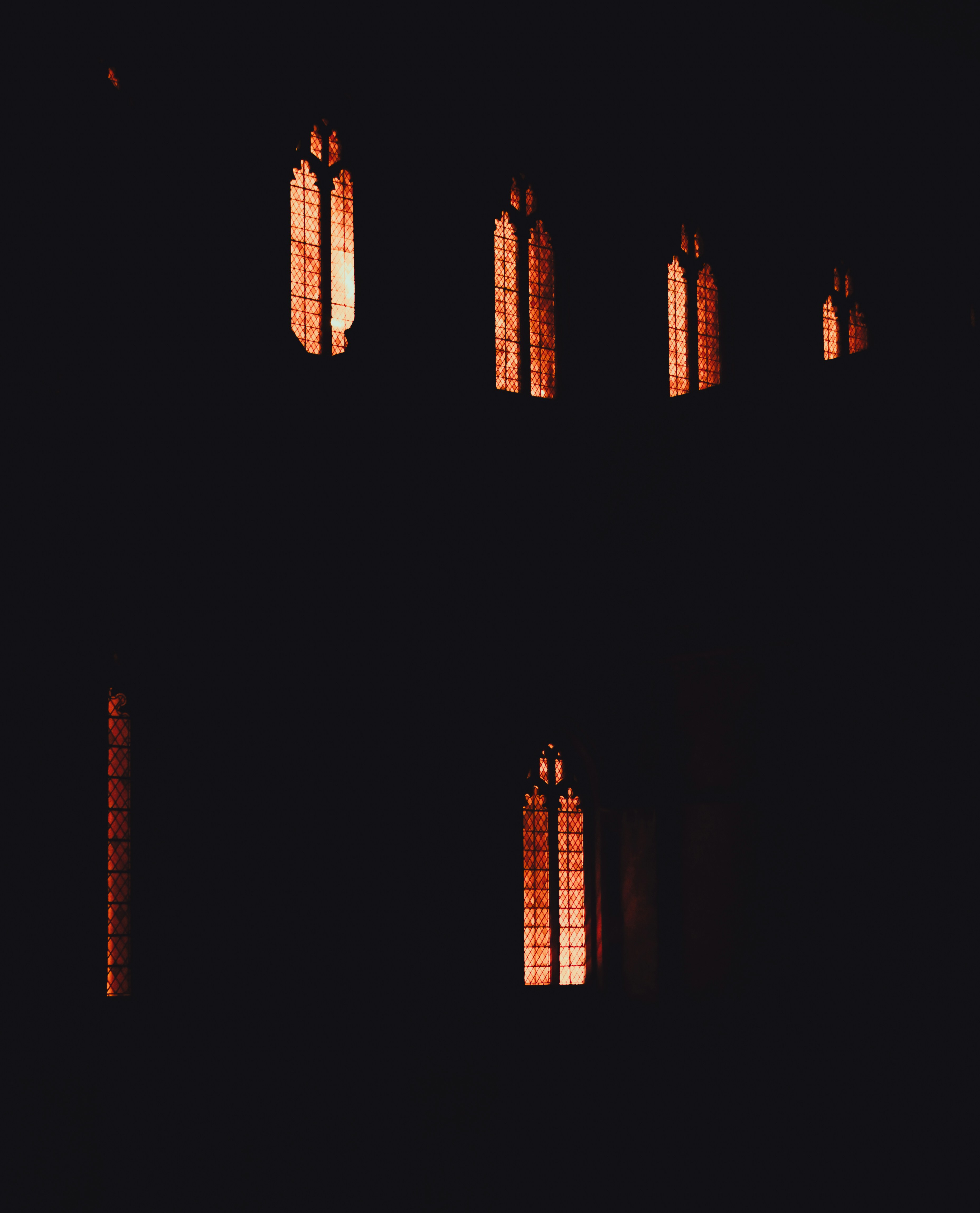 A building with many windows lit up in the dark photo – Free Windows ...