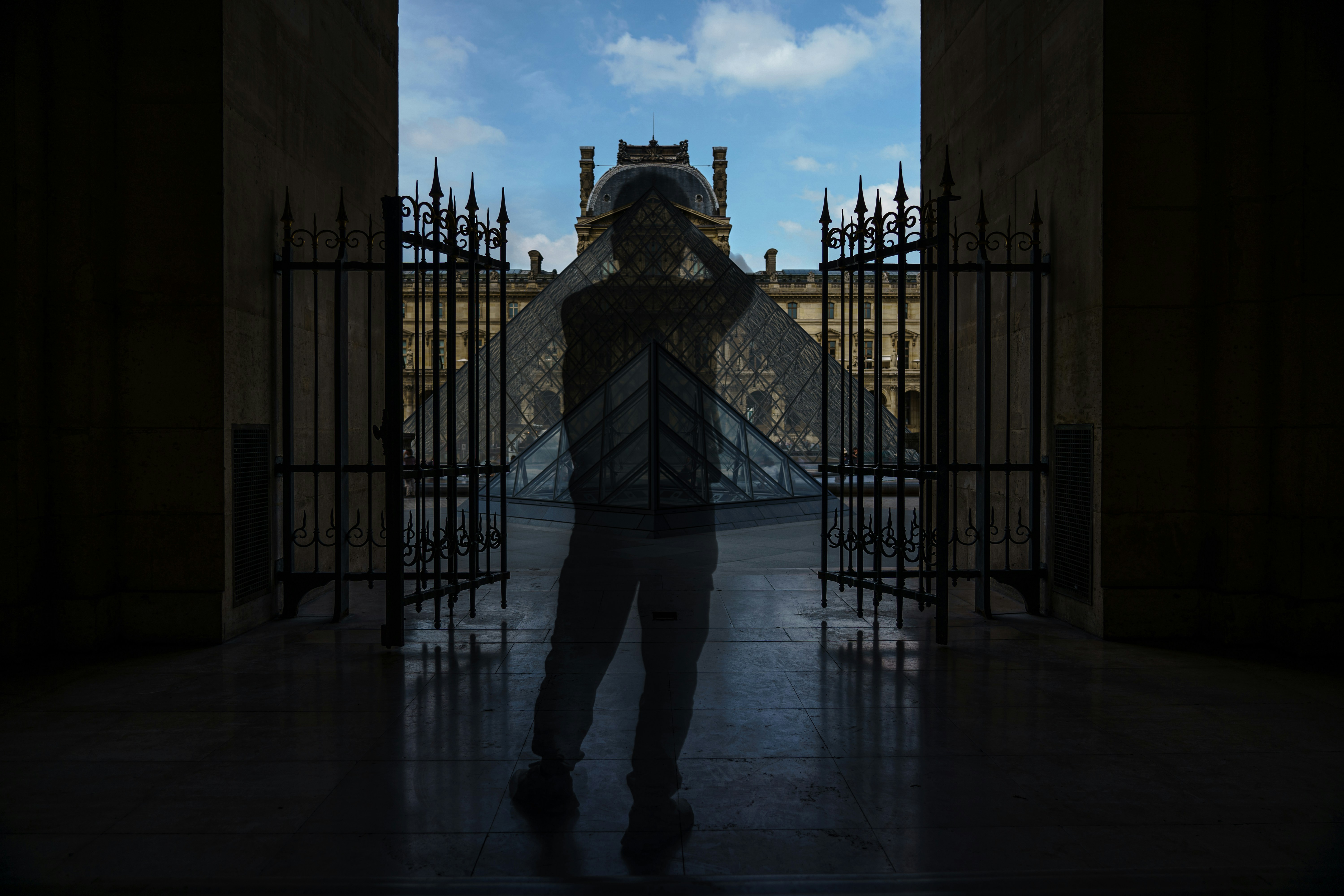 A man standing in front of an iron gate photo – Free Man Image on Unsplash