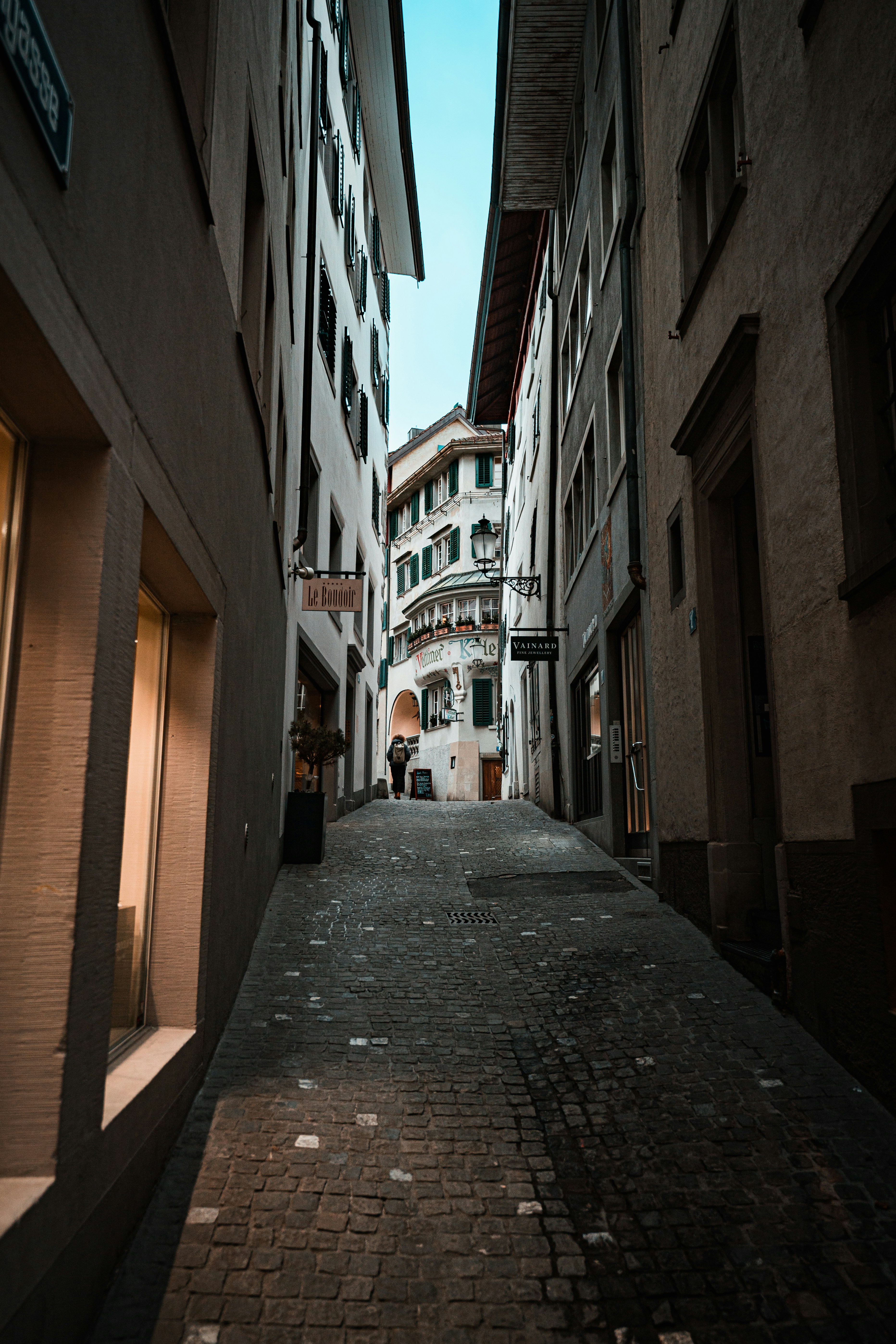 A narrow city street with buildings on both sides photo – Free Grey ...