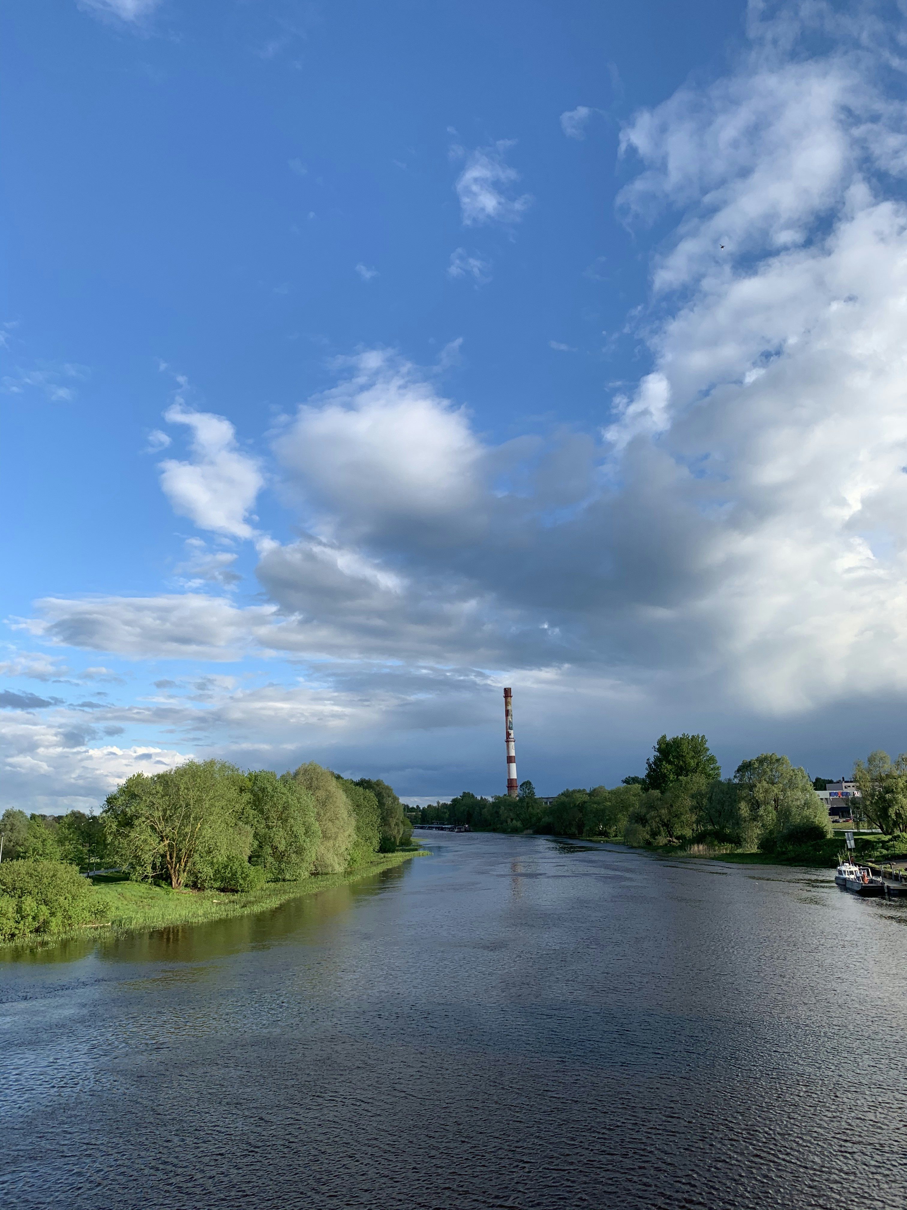 The Smokestack Over a Quiet River: Trees, Sky, and Industrial Silhouette