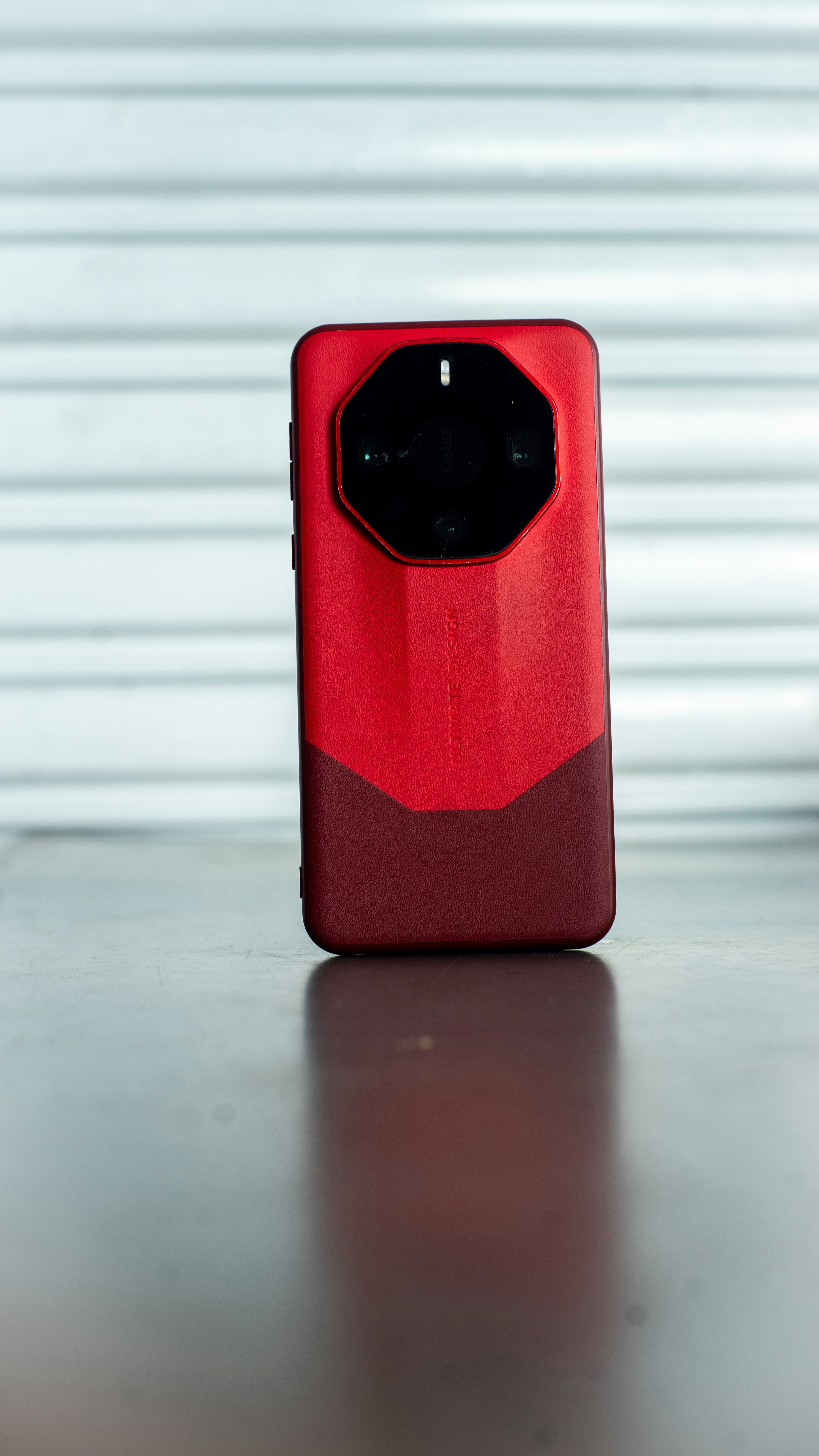 Crimson Backdrop: Red Phone with an Octagonal Camera in a Minimal Studio