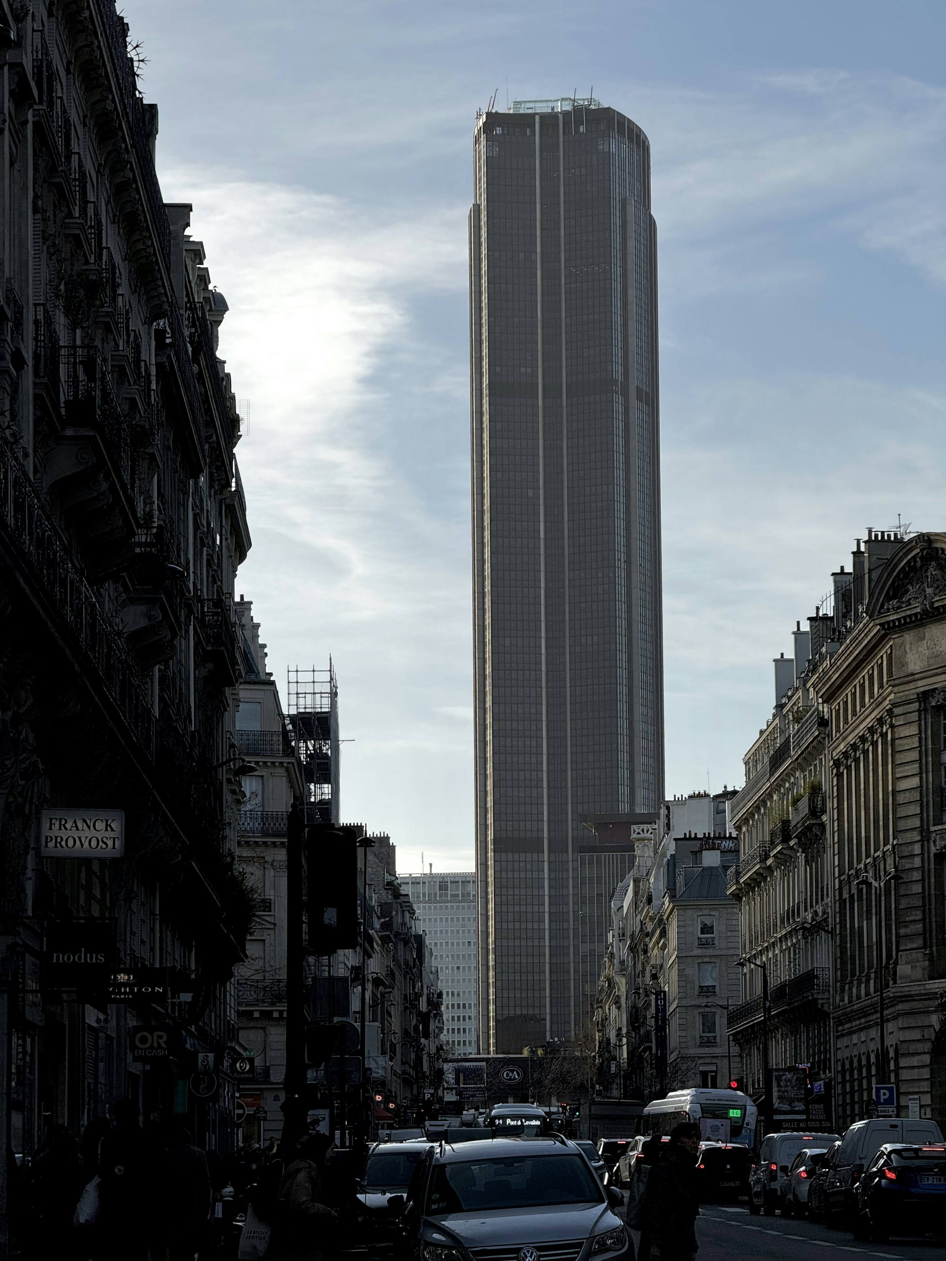 A very tall building towering over a city filled with traffic photo ...