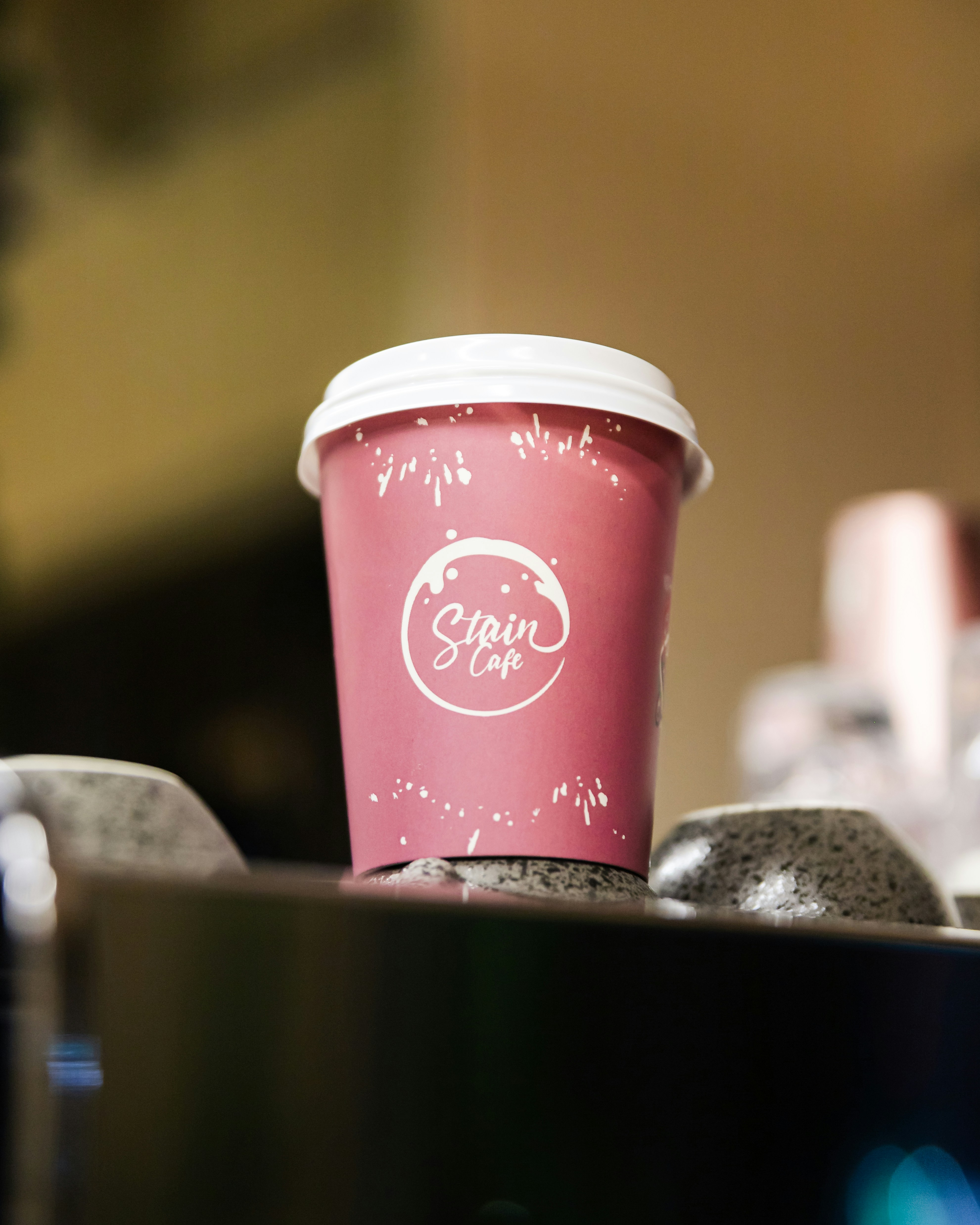 Centerstage Pink Cup: The Stain Café Logo Adrift in a Quiet Café Blur