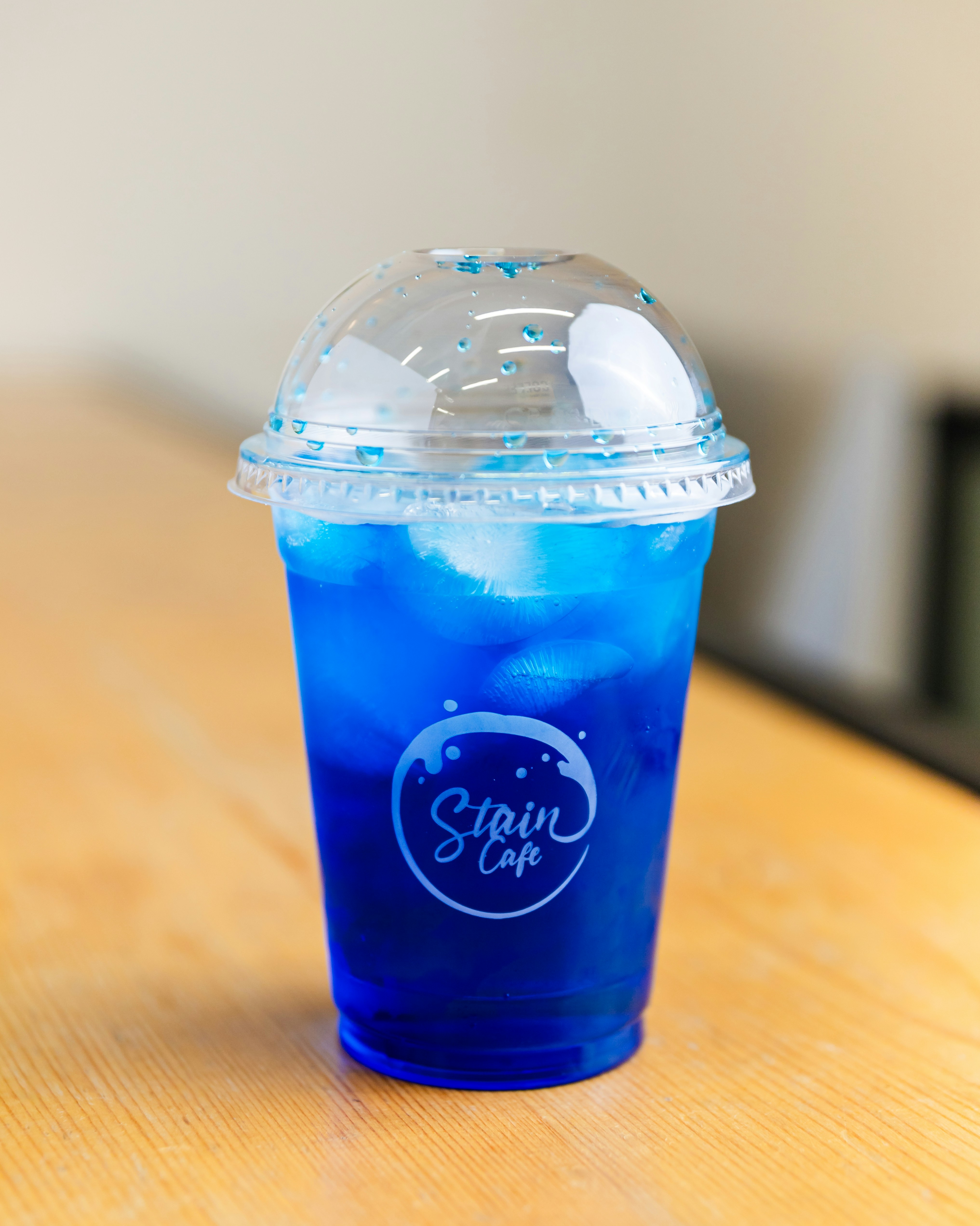 Cobalt Slush Under a Clear Dome: A Quiet Café Moment on Warm Wood
