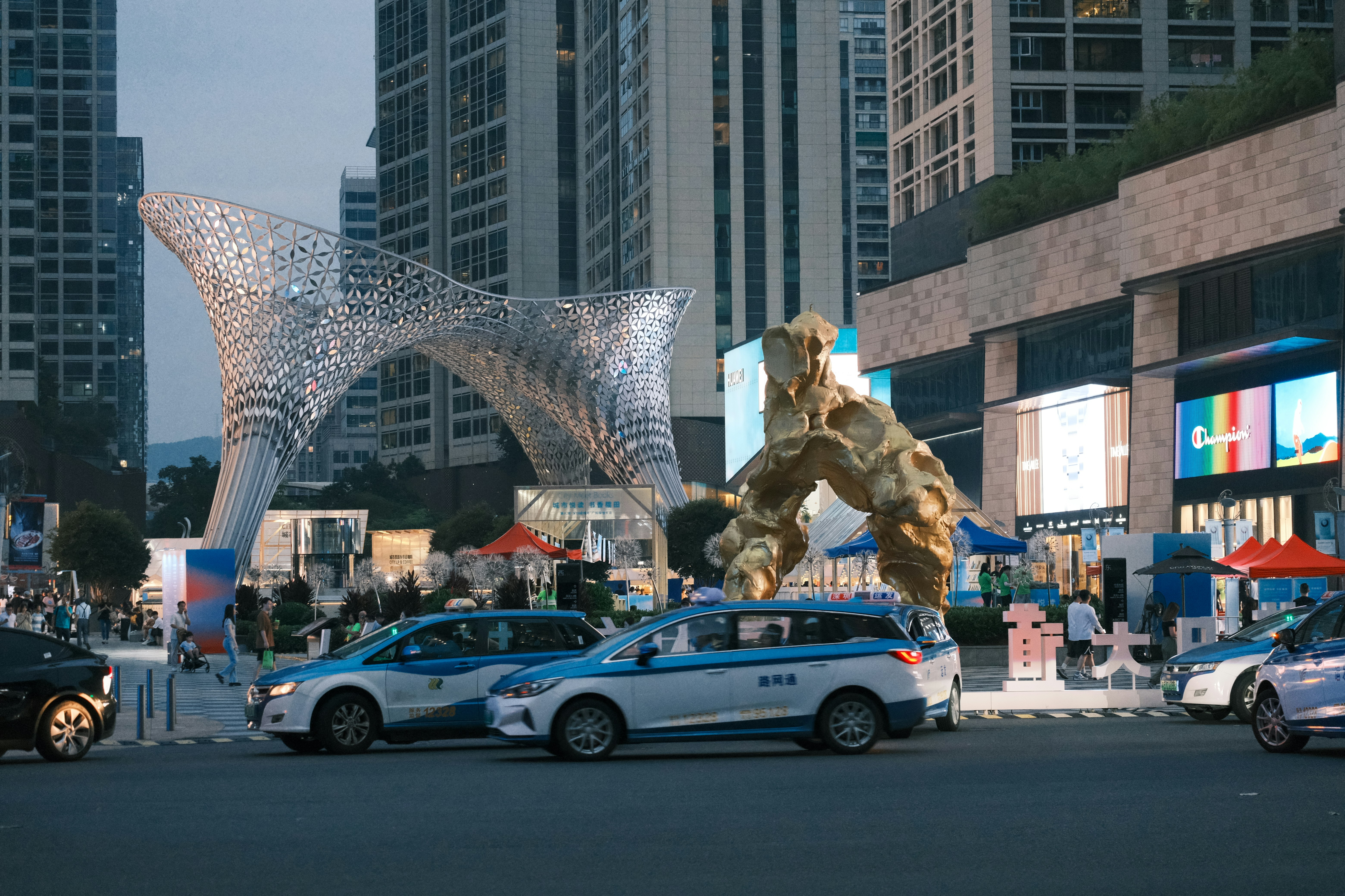 Gilded Figure Under the Lattice Arch: A City Square at Dusk
