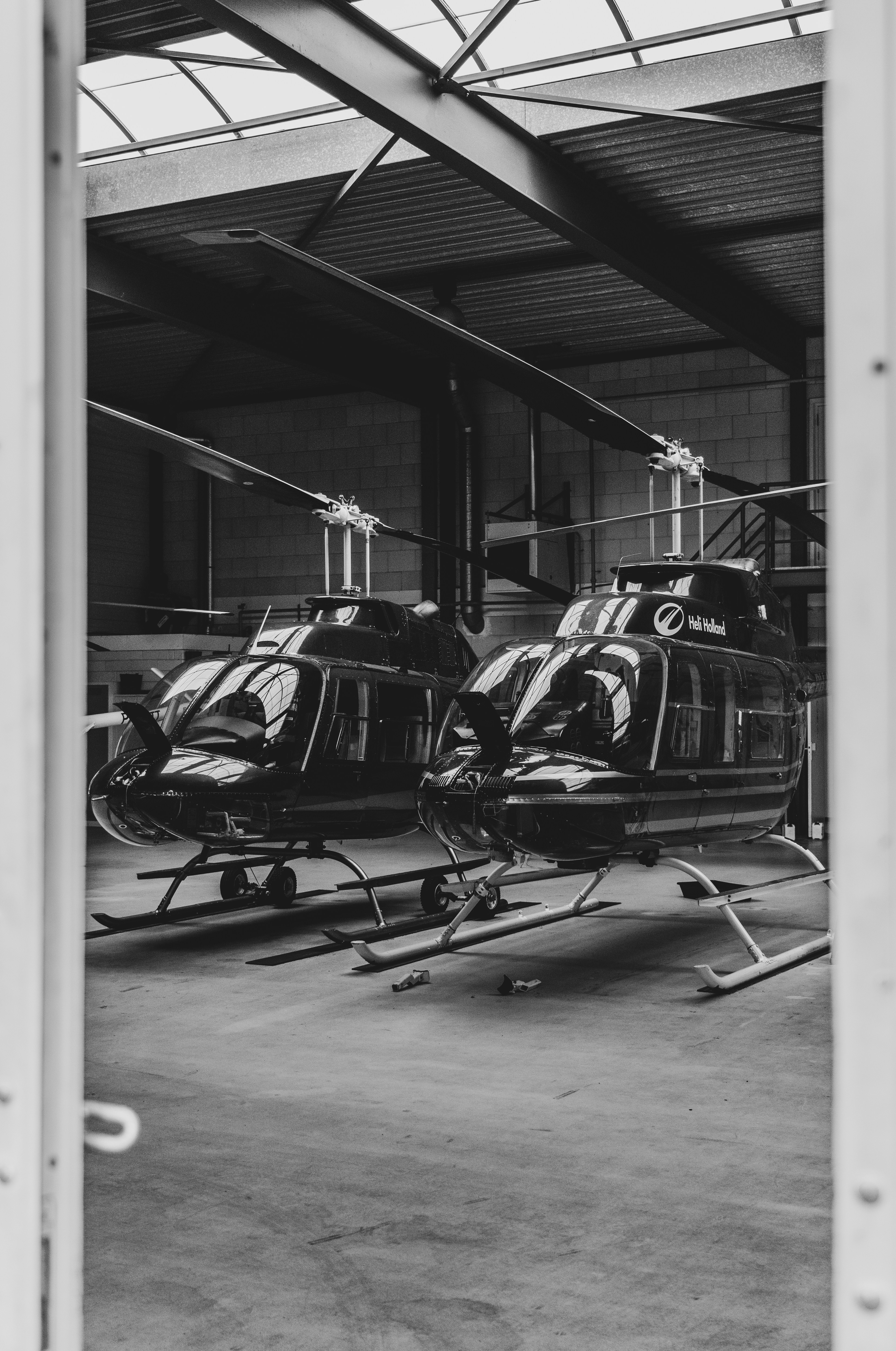 A couple of black and white helicopters parked in a hangar photo – Free ...