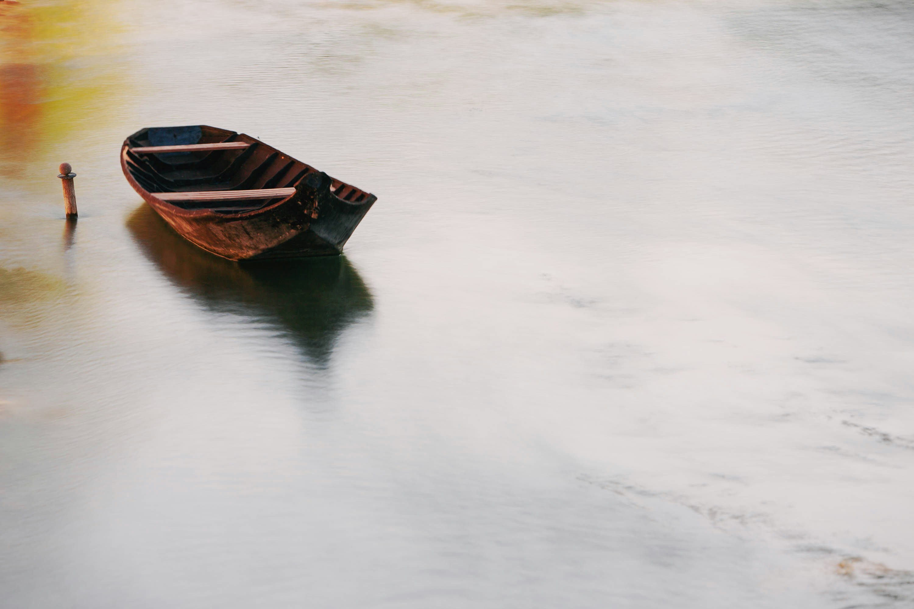 A small boat floating on top of a body of water photo – Free Boat Image ...