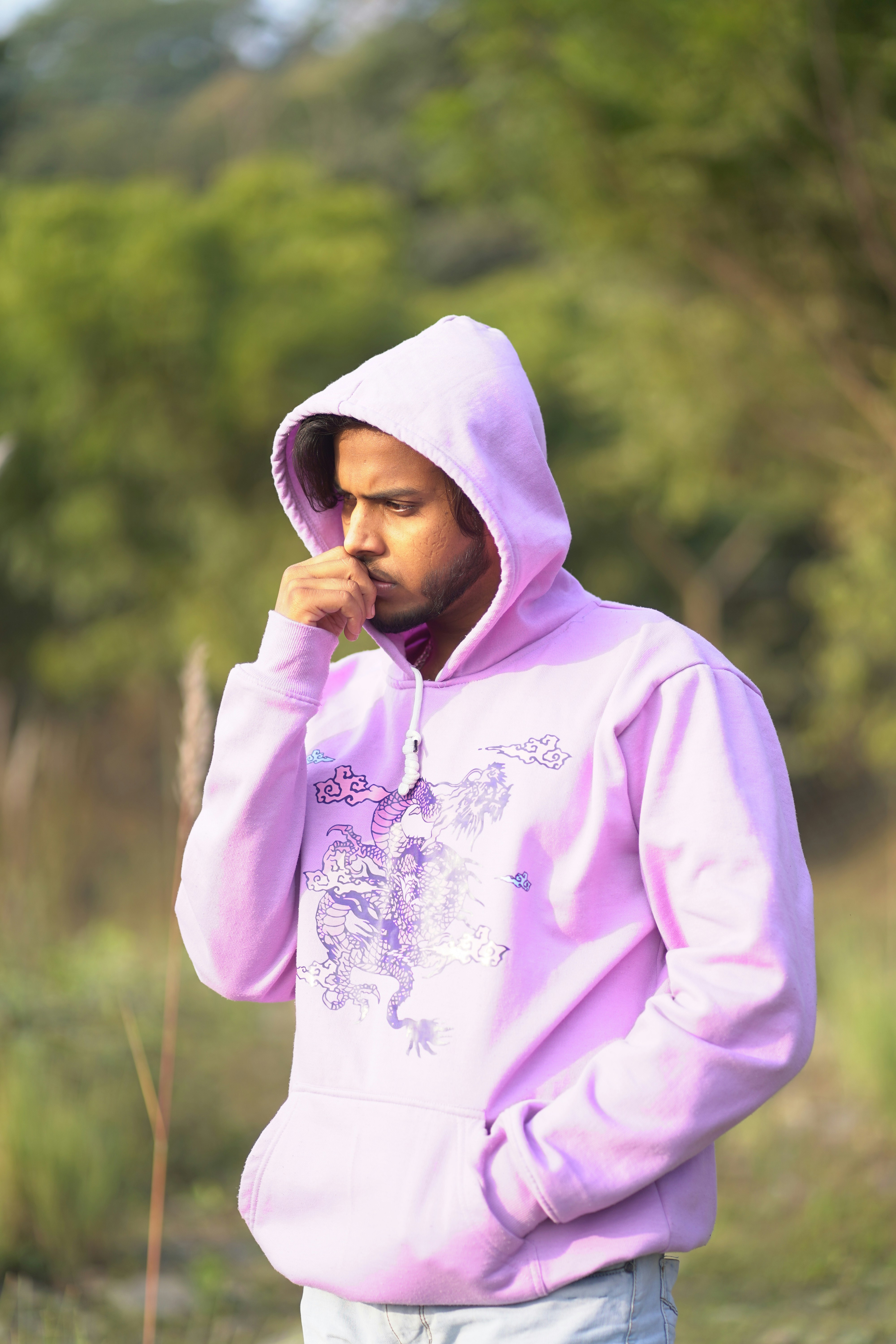 Contemplative Moment in a Lavender Hoodie Amid Quiet Greenery