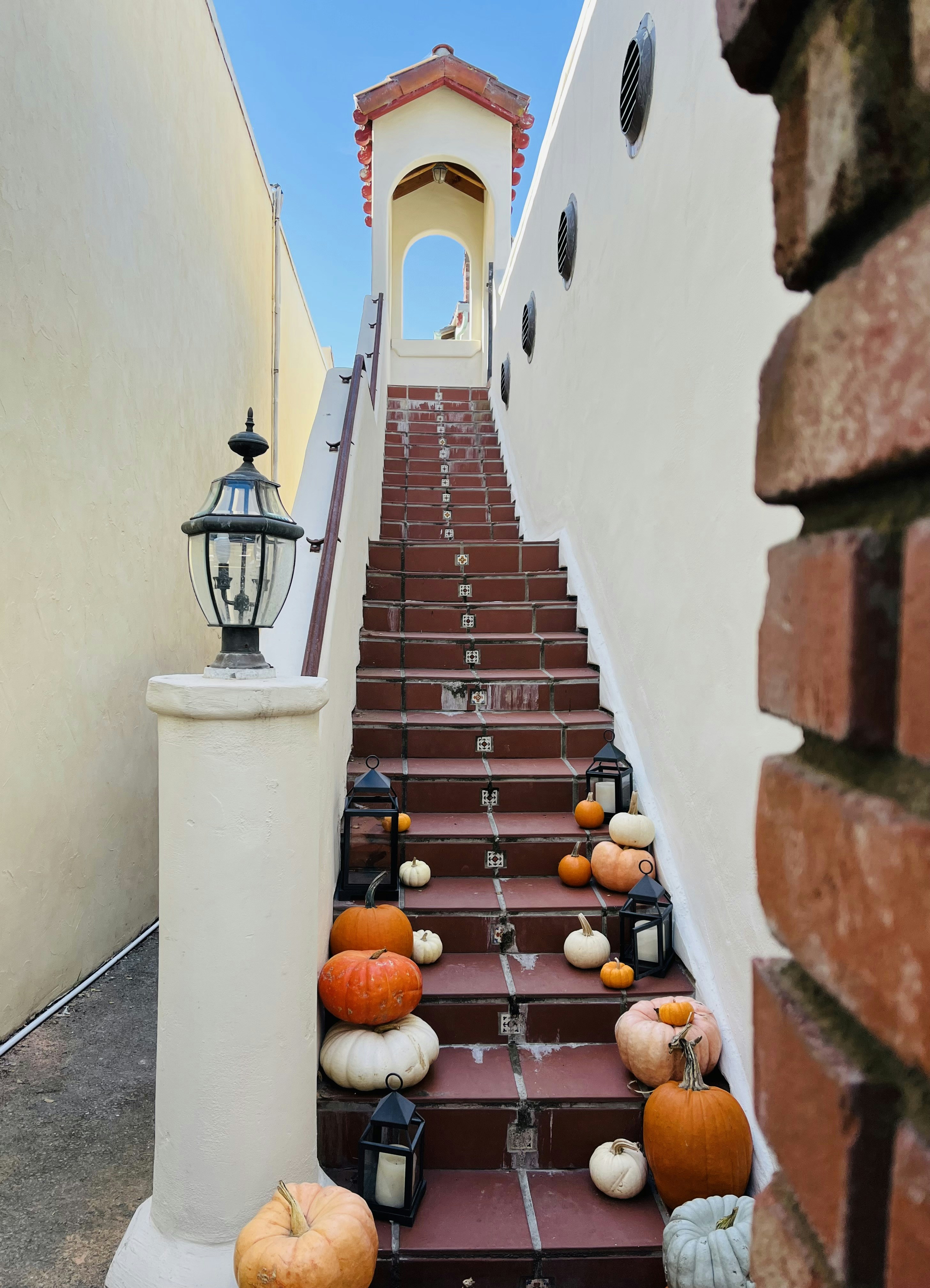 Pumpkins on the Ascent: A Staircase Toward a Sunlit Arch