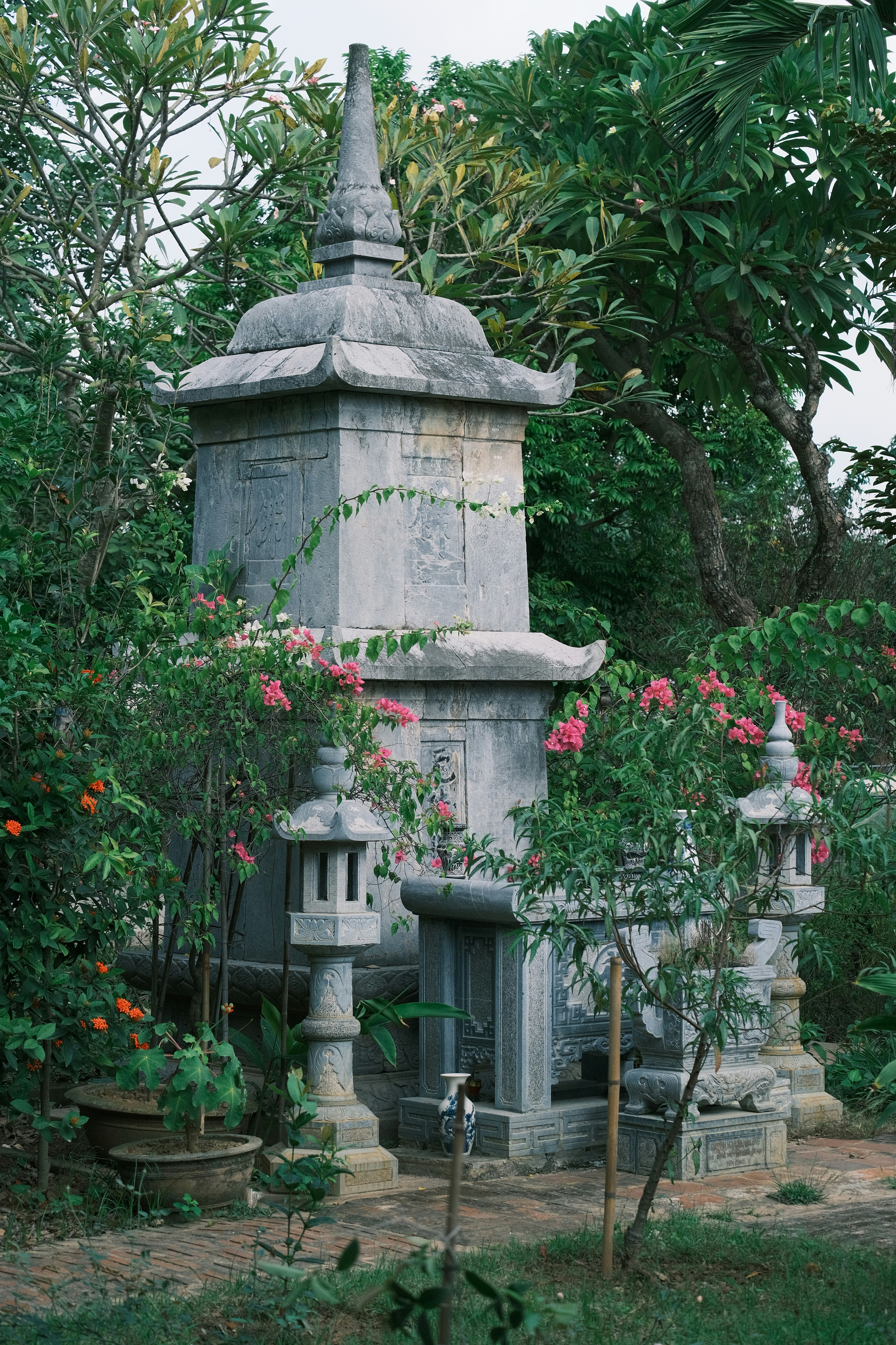 A stone monument surrounded by trees and flowers photo – Free Chùa bút ...