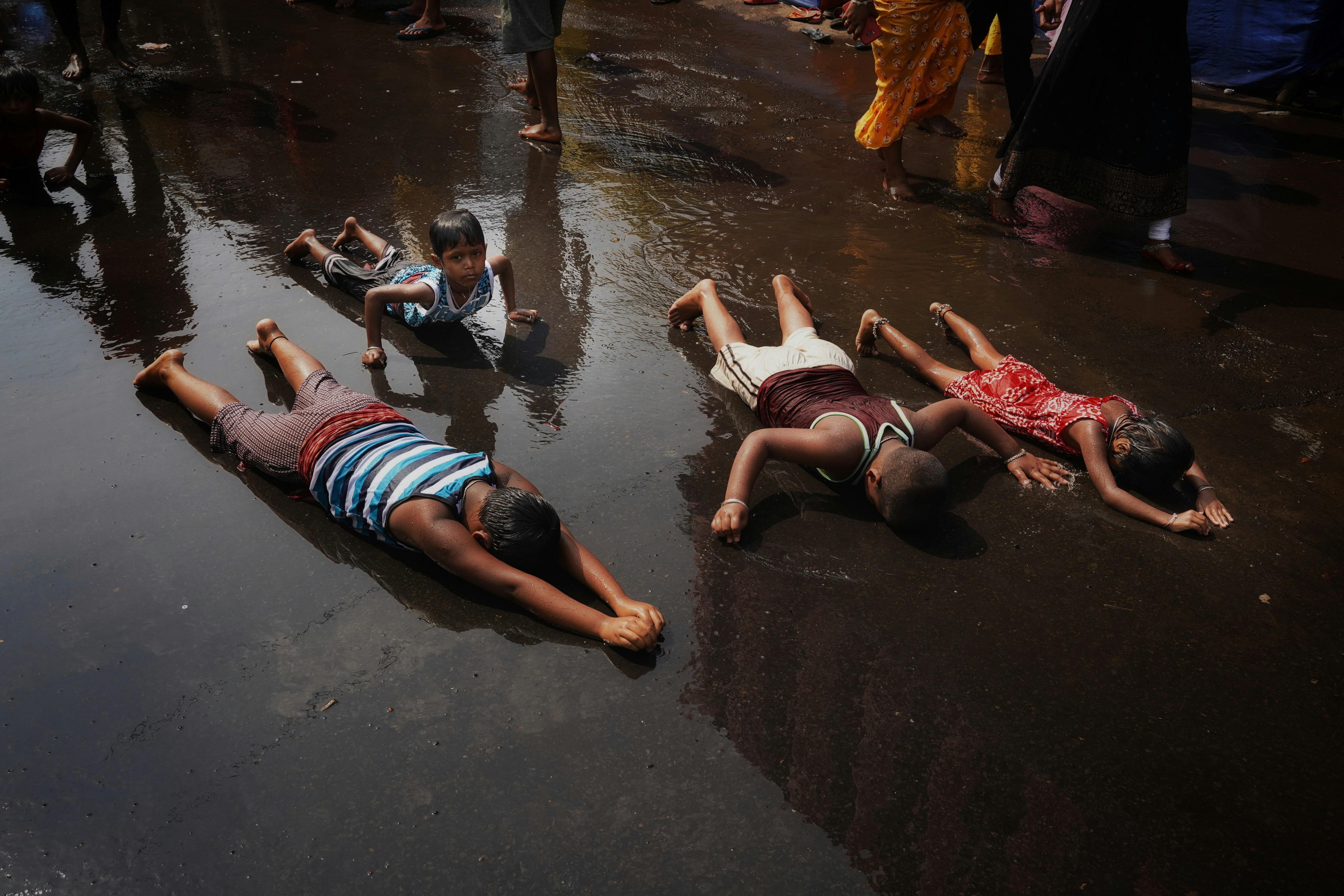 A group of people laying on the ground in the rain photo – Free People ...