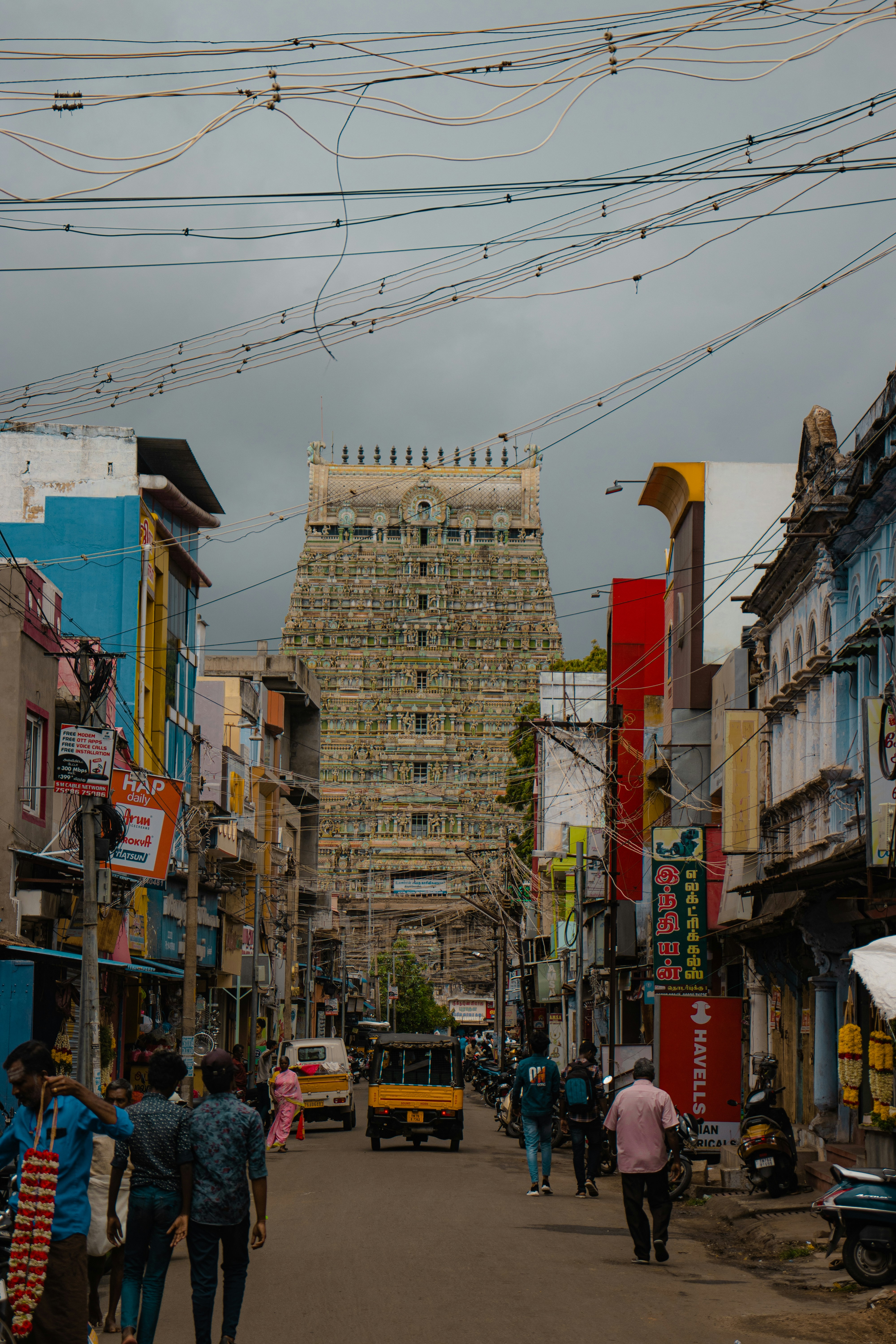 A group of people walking down a street next to tall buildings photo ...