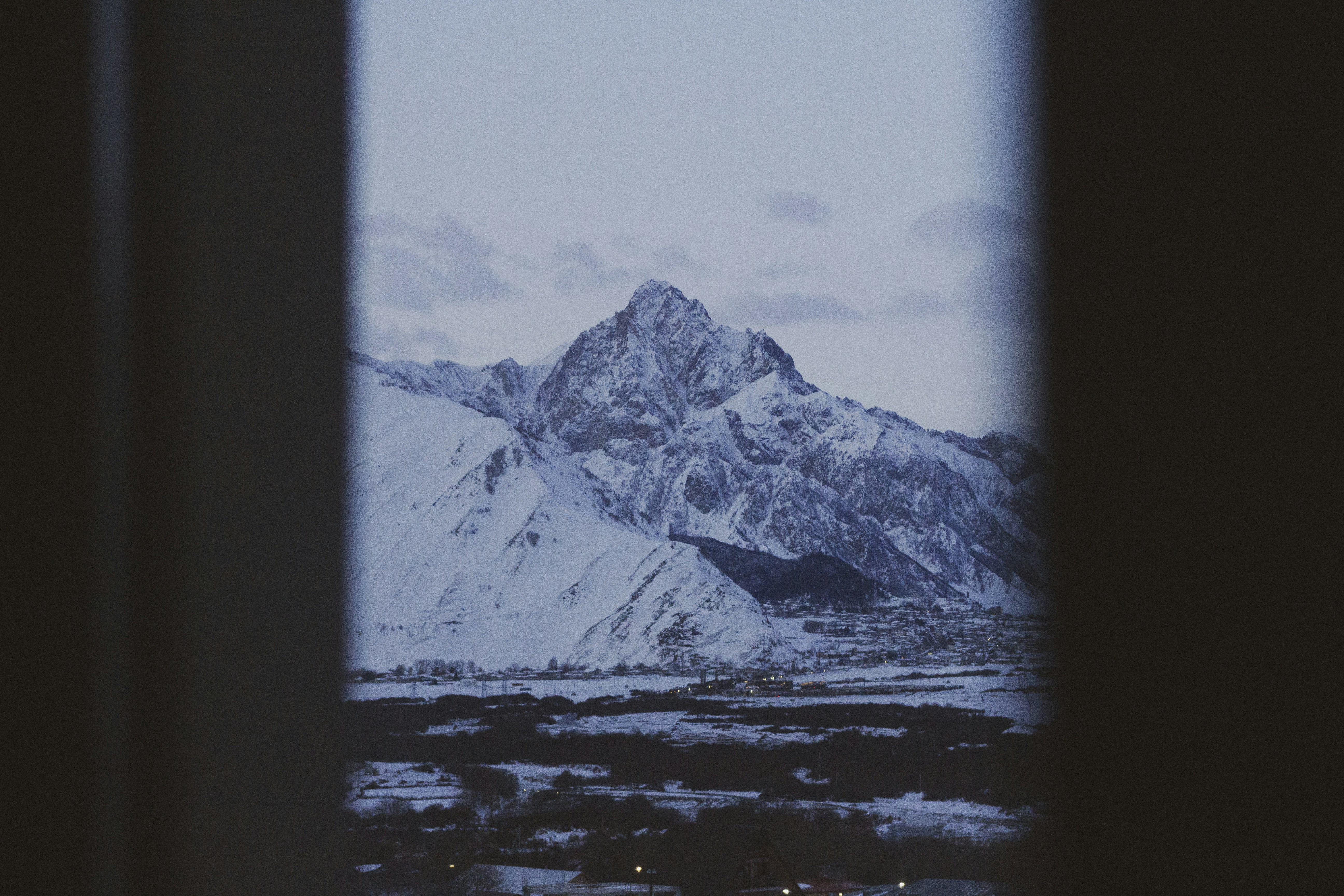 Peak Through a Narrow Frame: Alpine Summit Seen Between Dark Window Gaps