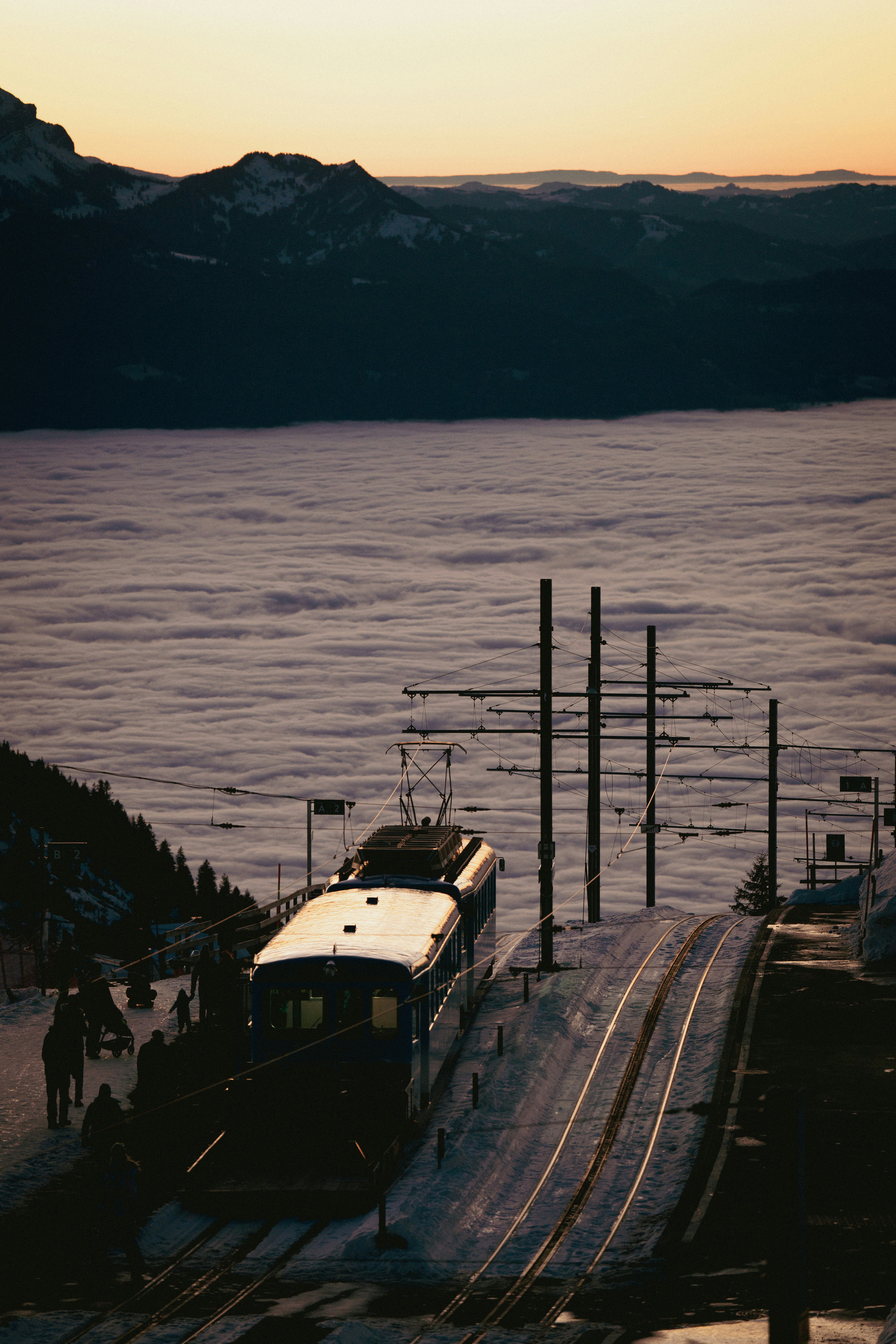 A train traveling down tracks next to a body of water photo – Free Sea ...
