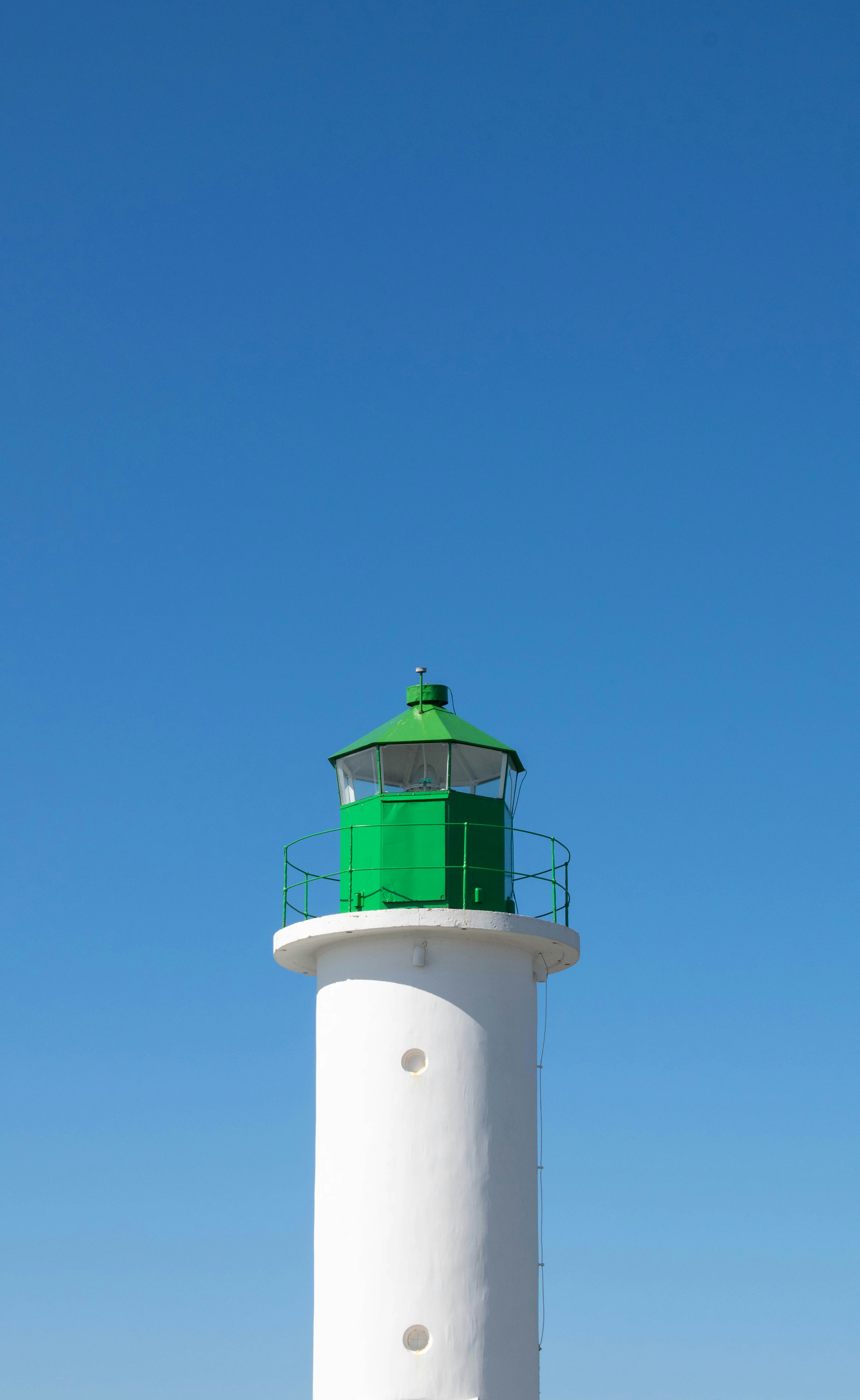 A white and green lighthouse on a clear day photo – Free Ventspils ...