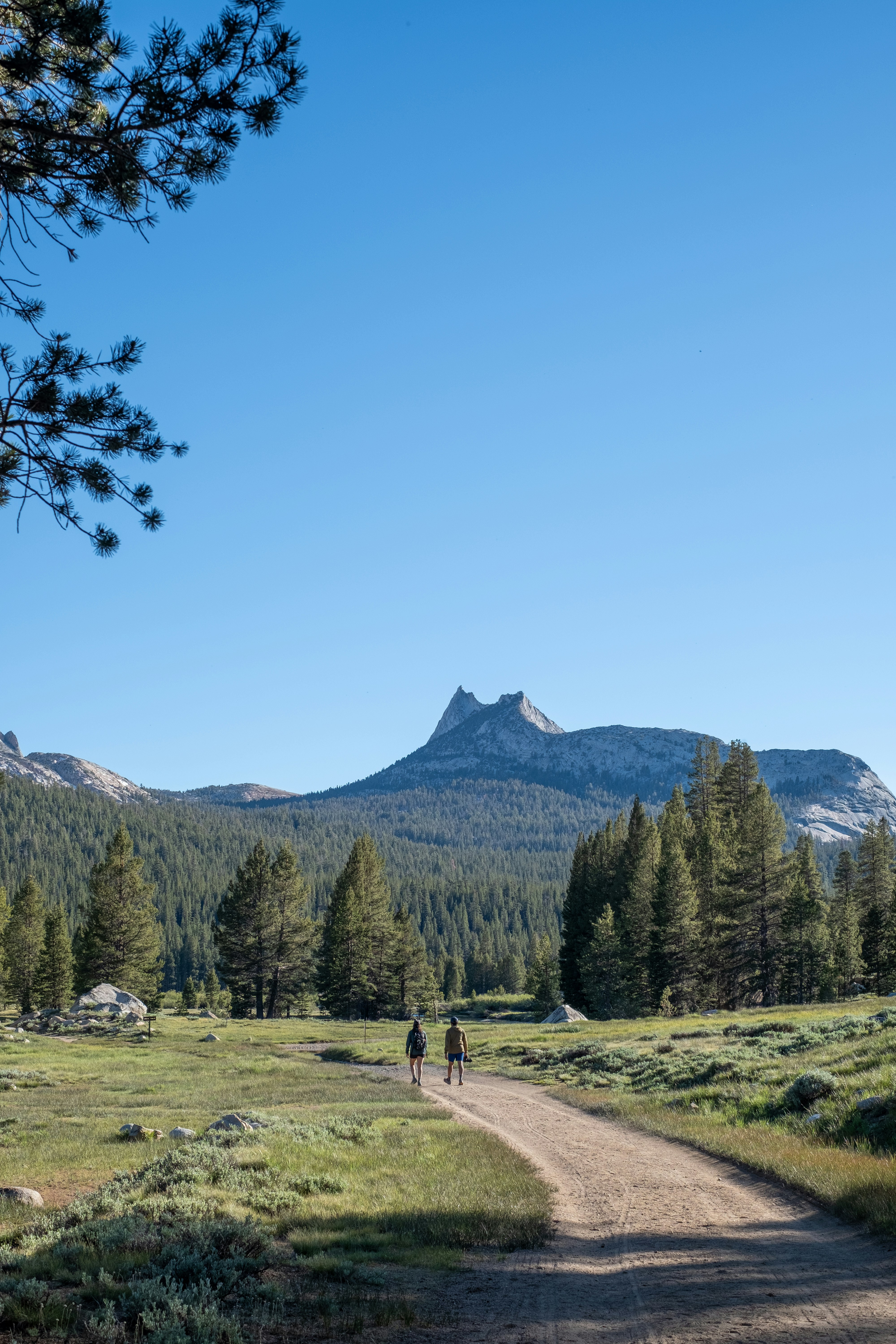 Two Hikers on a Dusty Sierra Path Beneath a Jagged Peak