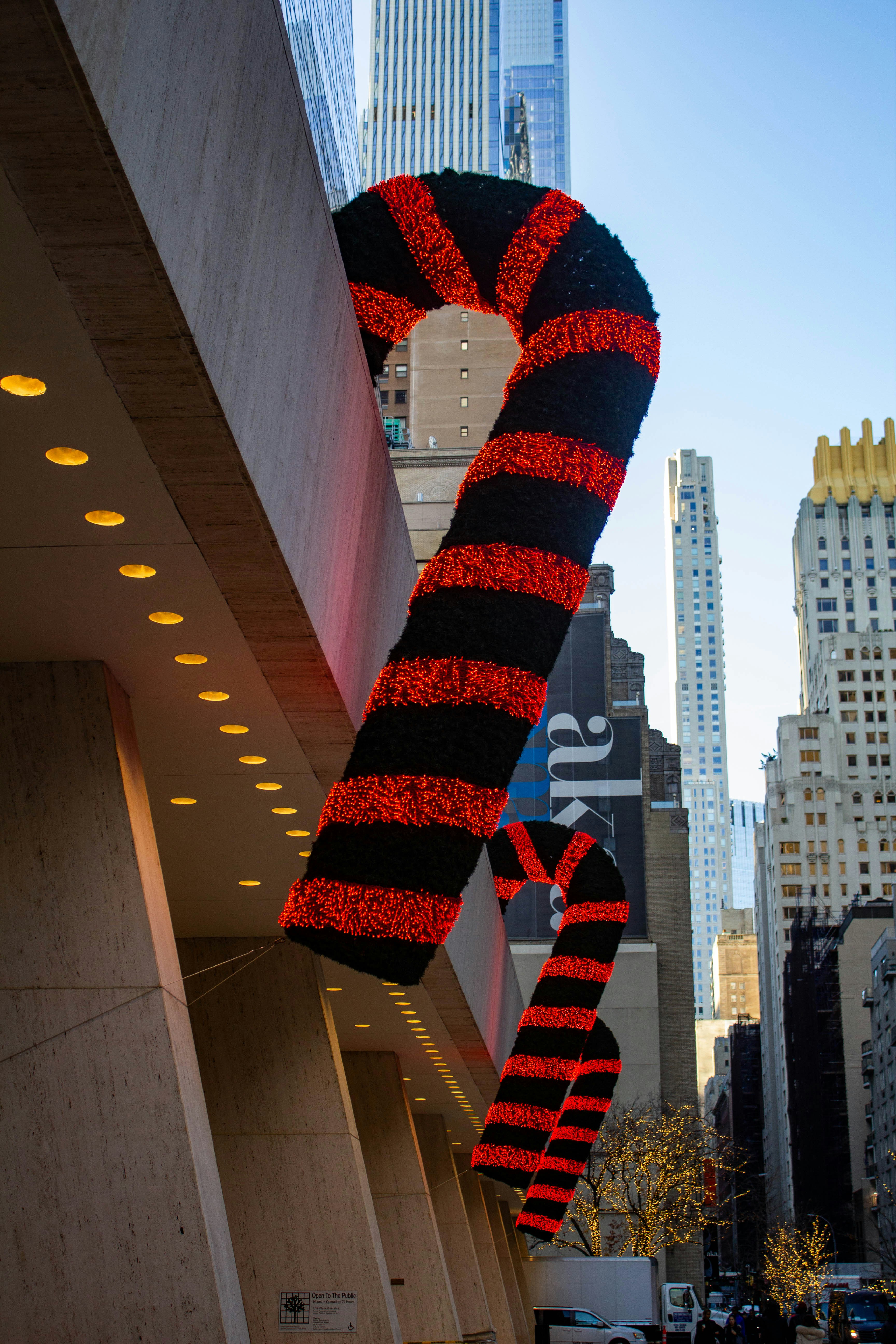 A large candy cane hanging from the side of a building photo – Free ...