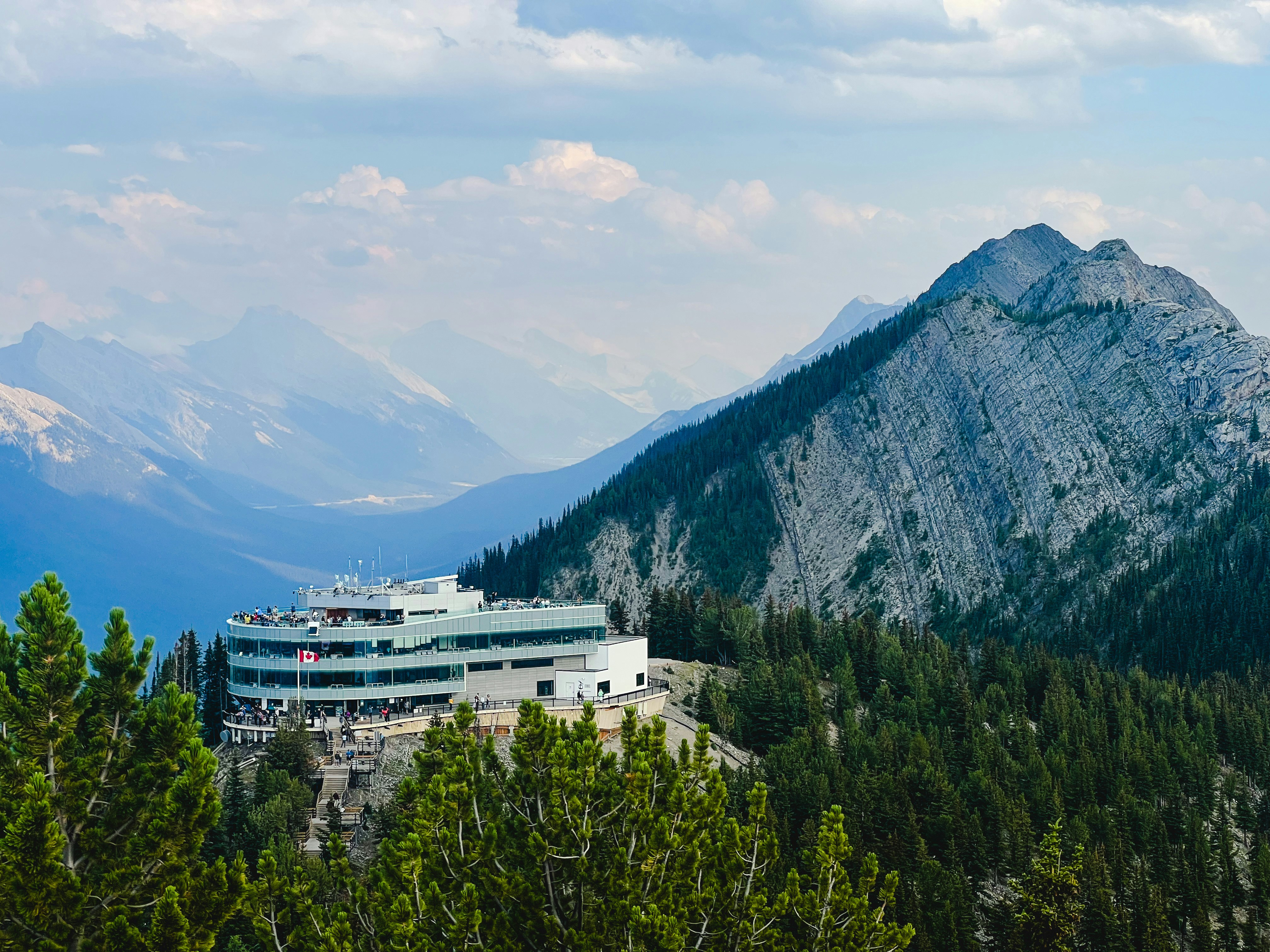 A building on top of a mountain surrounded by trees photo – Free ...