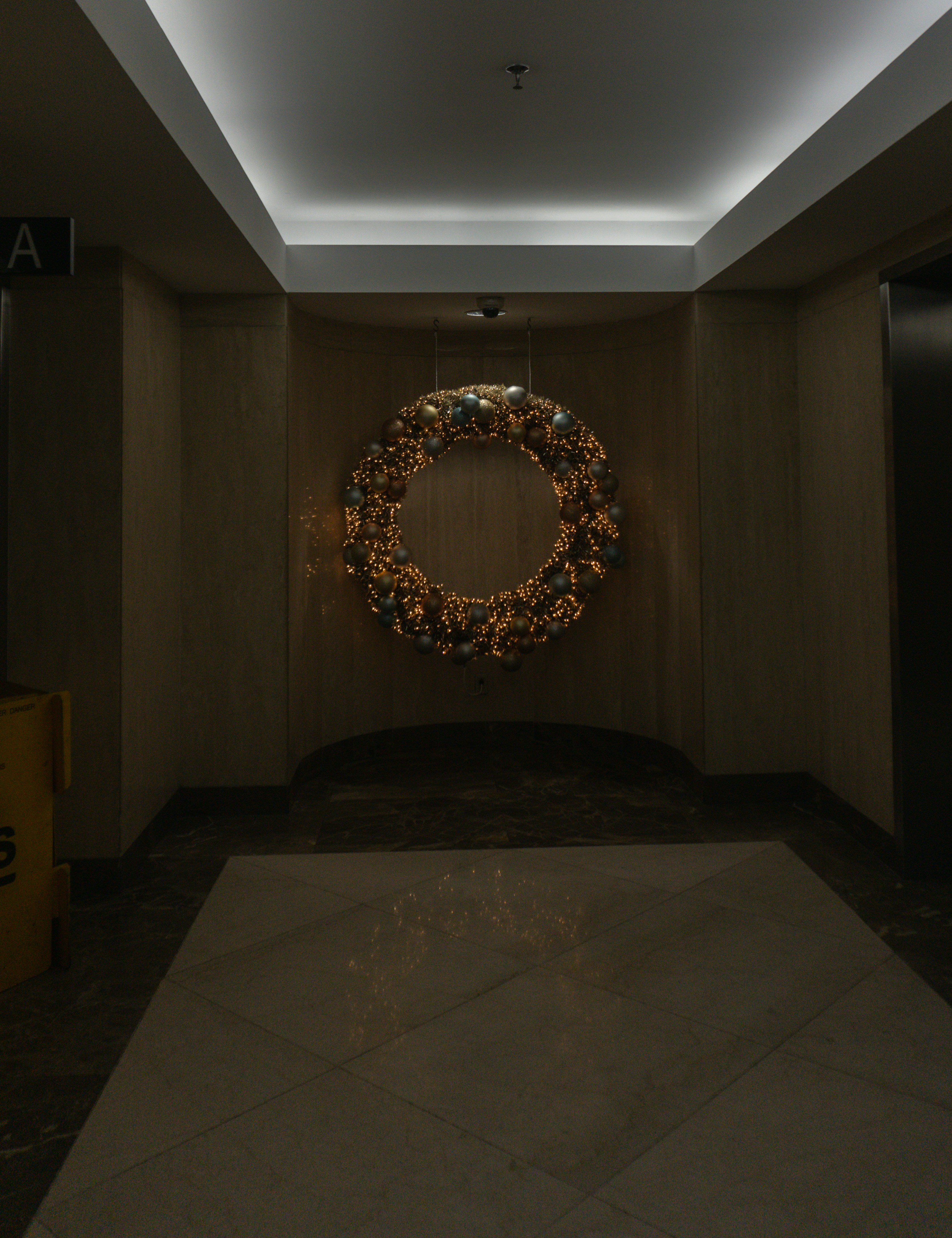 Ornamental Halo: A Wreath of Lights in a Marble-Lit Lobby