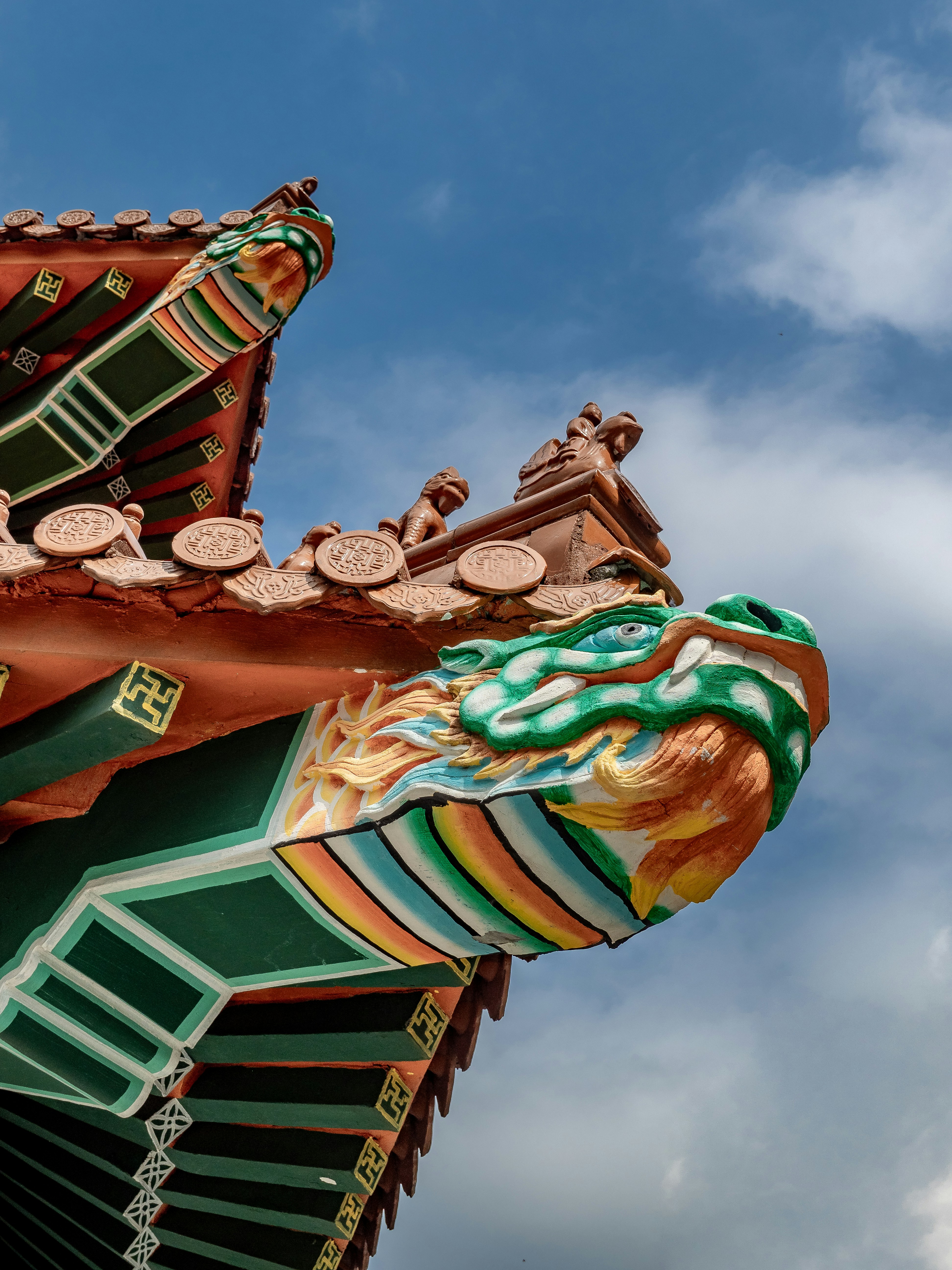 Dragon's Gaze on a Temple Roof: Color and Craft Under a Clear Sky