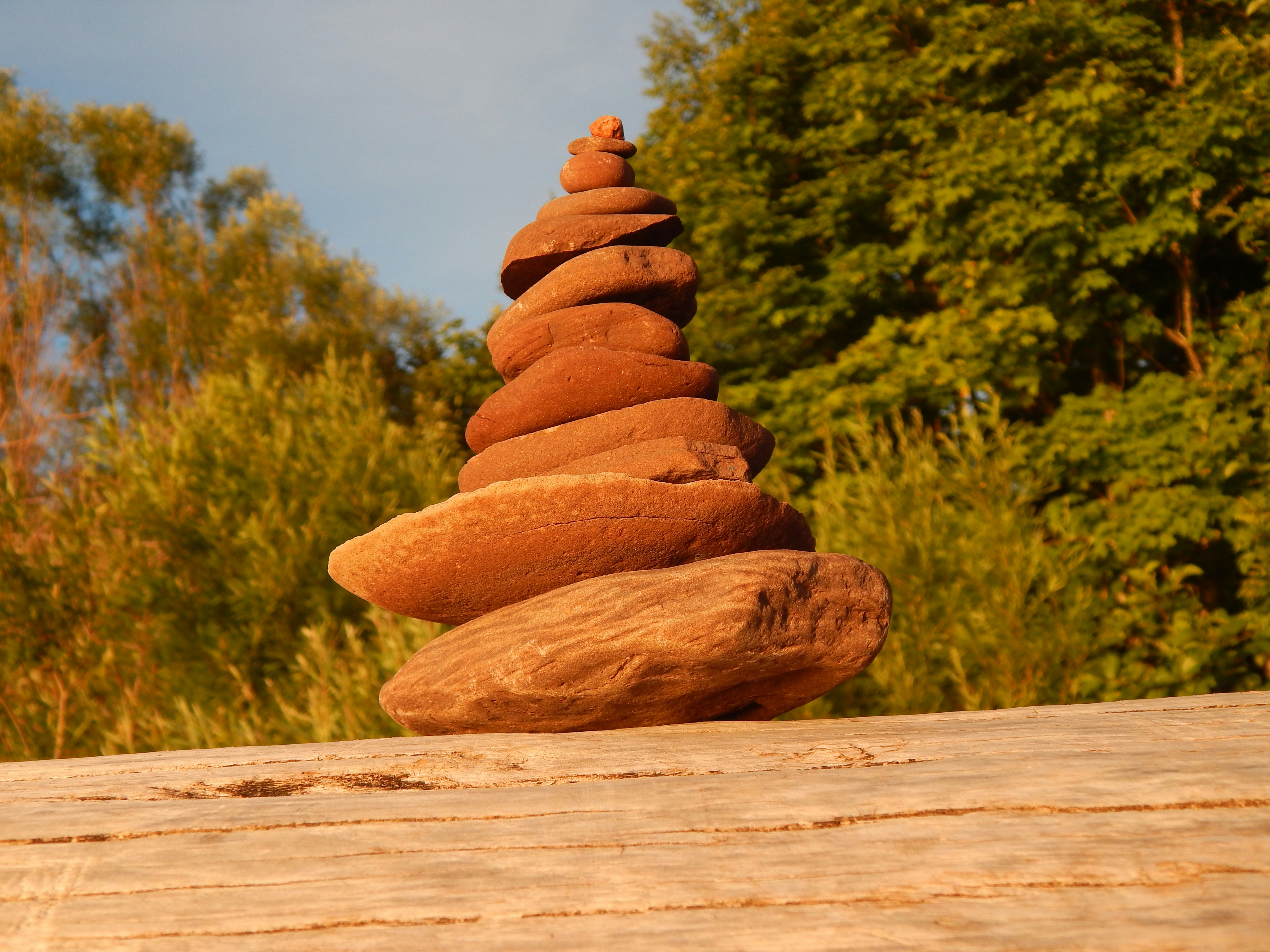 Cairn of Quiet Balance on a Sun-Warmed Wooden Table