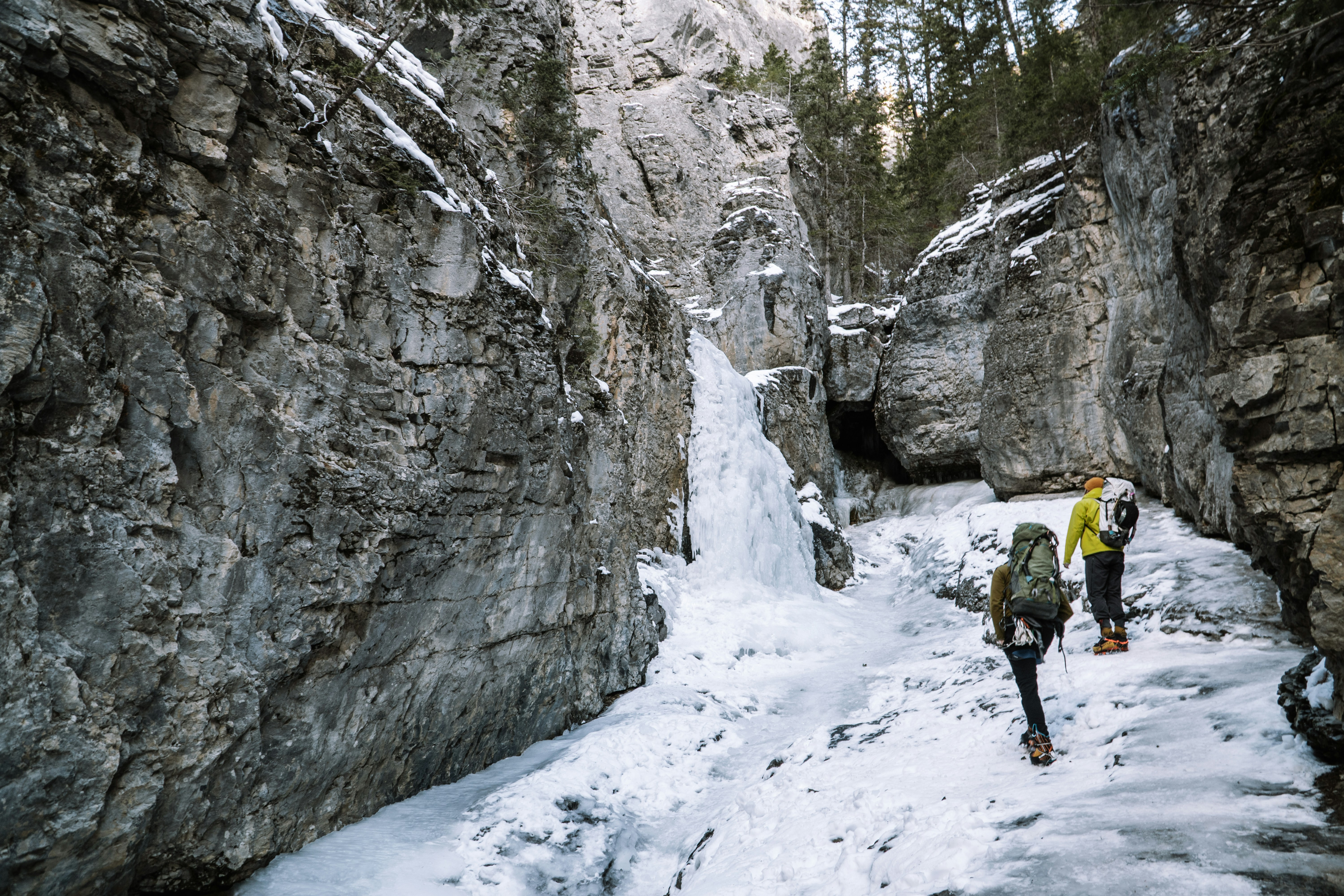 A couple of people walking up a snow covered slope photo – Free Human ...