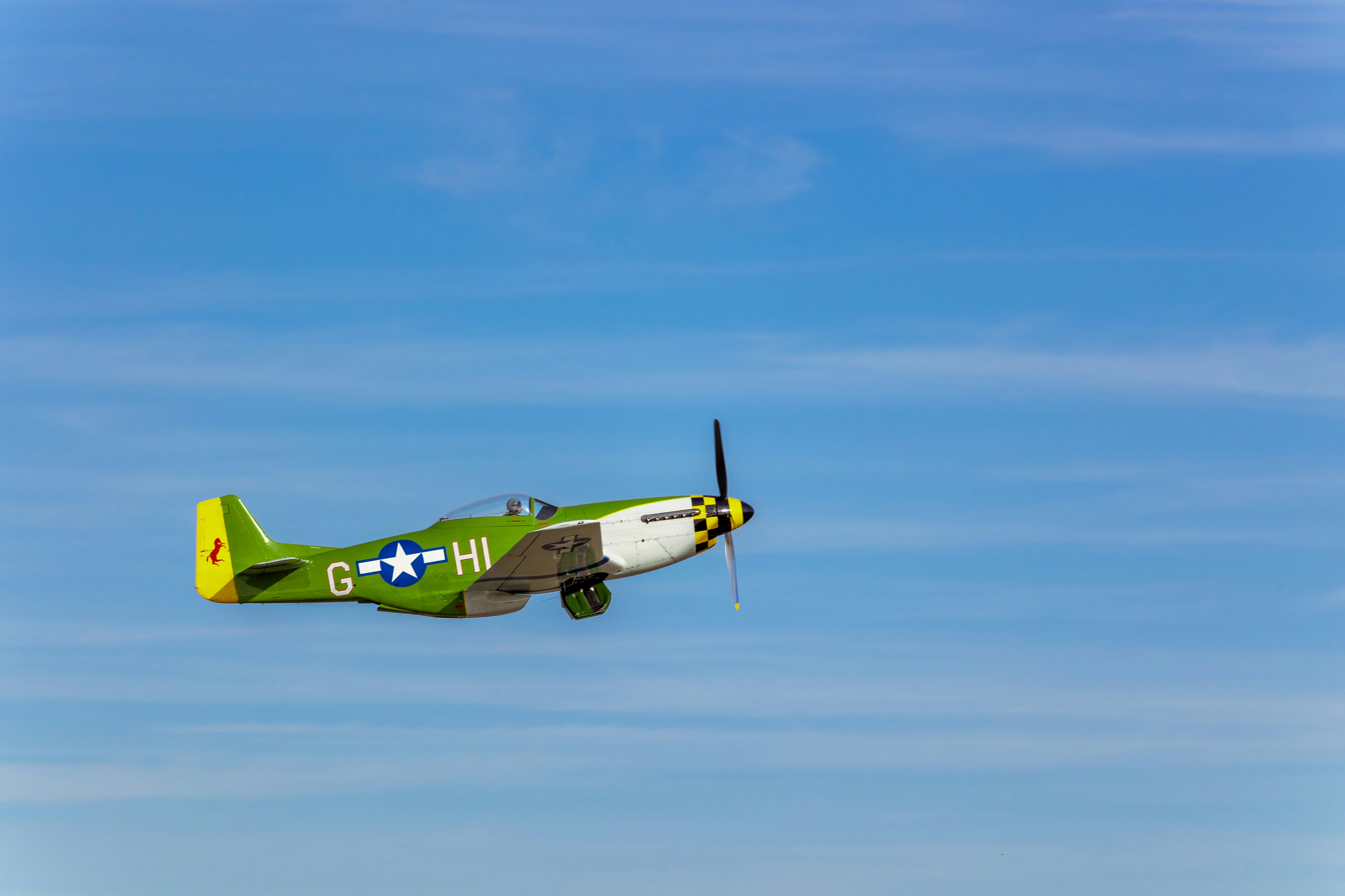 Emerald Warbird Skims the Azure: A Green WWII Fighter in Clear Skies