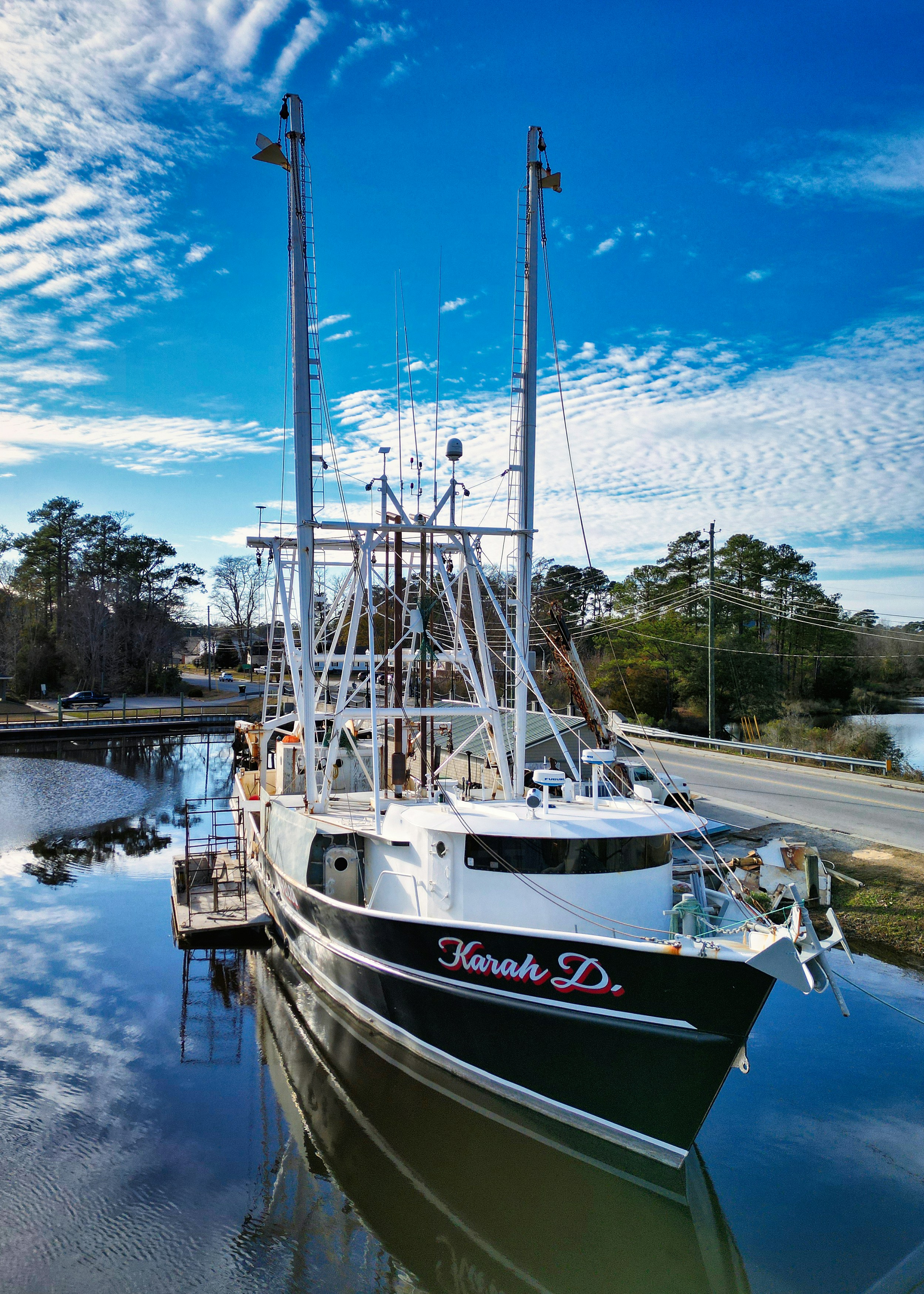 Harborbound Truss: A White-Blue Fishing Vessel Anchored in Calm Waters