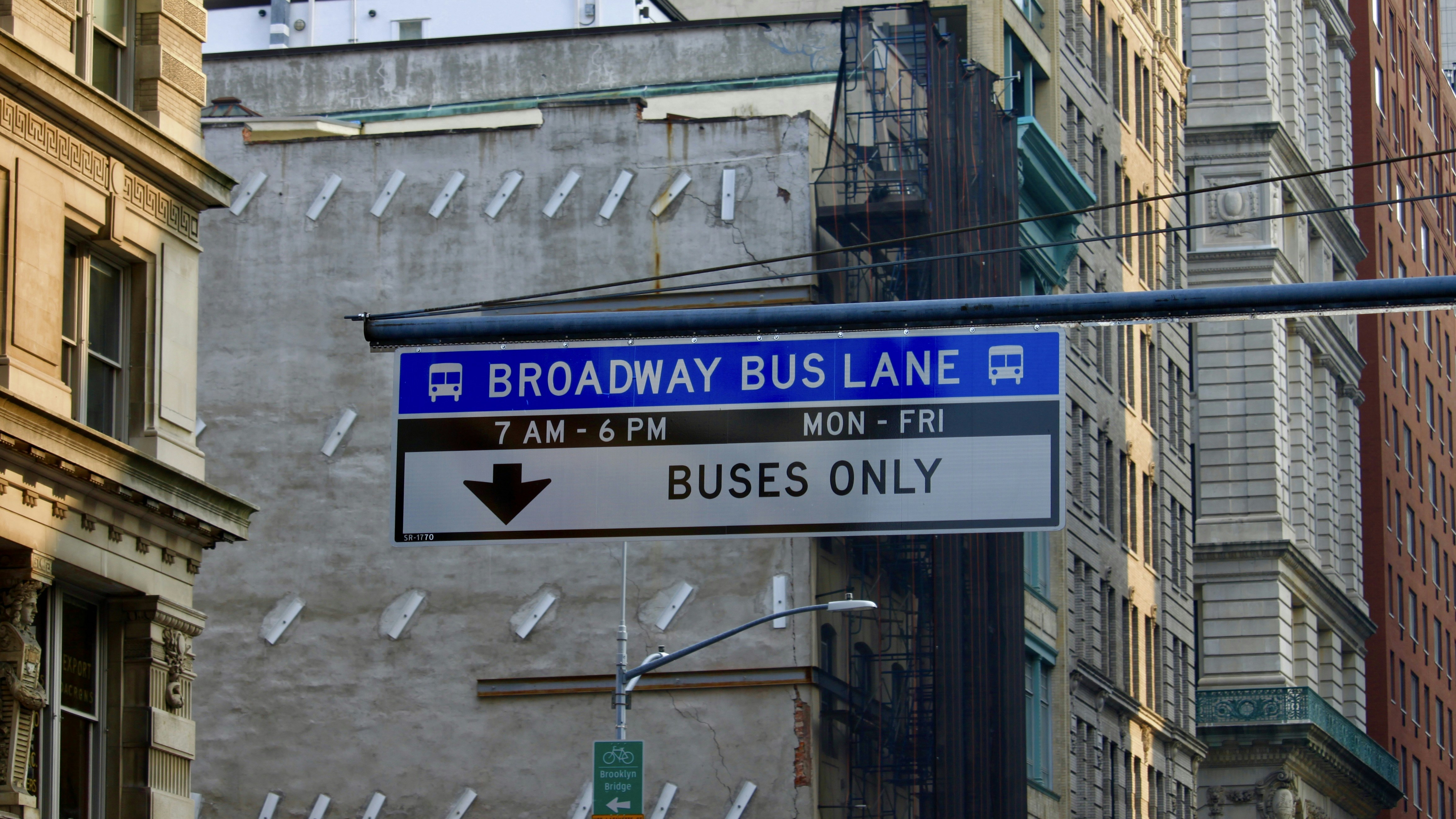 A blue and white street sign hanging from a metal pole photo – Free ...
