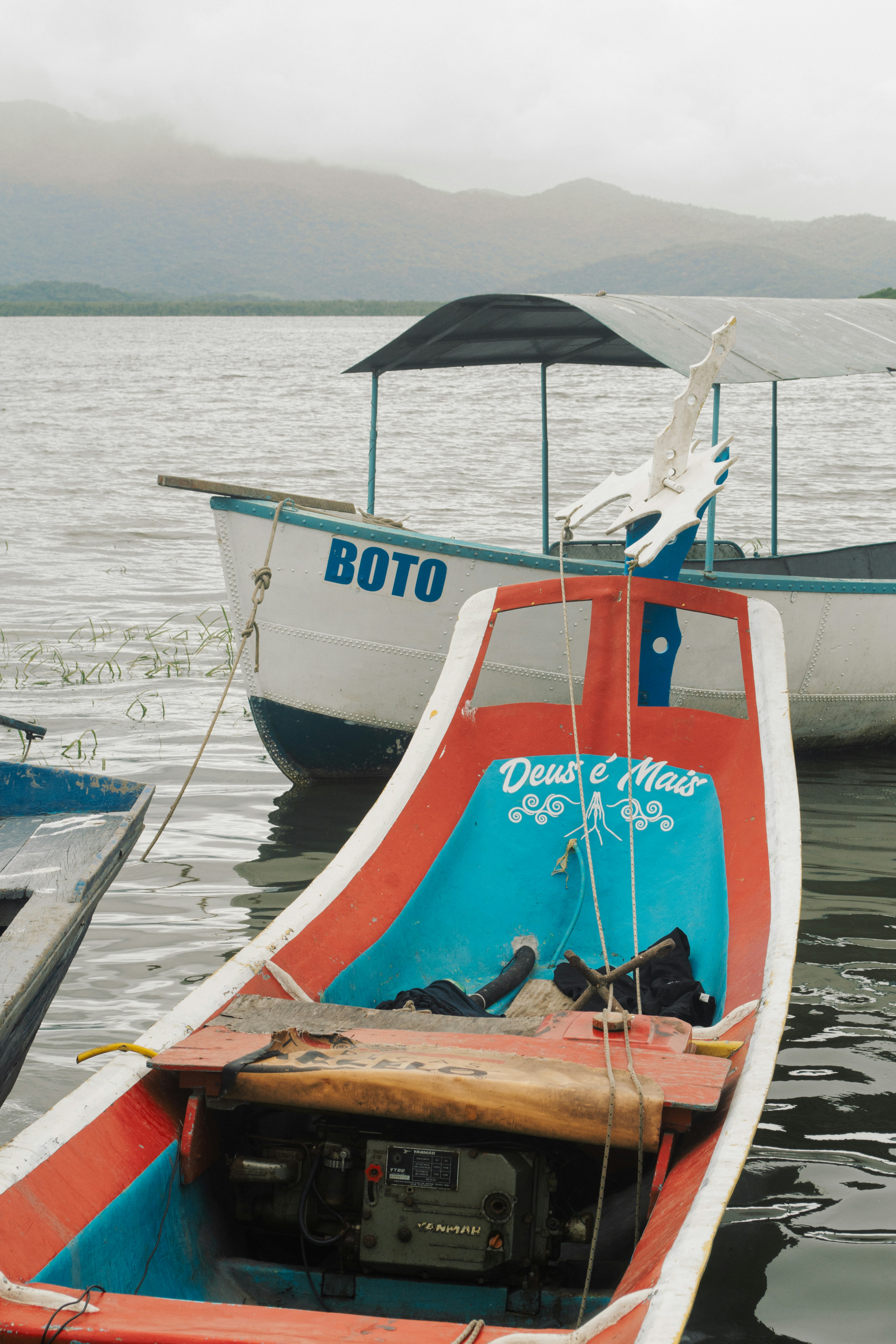 Deus é Mais on the Lake: A Palette of Painted Boats Resting by Calm Waters