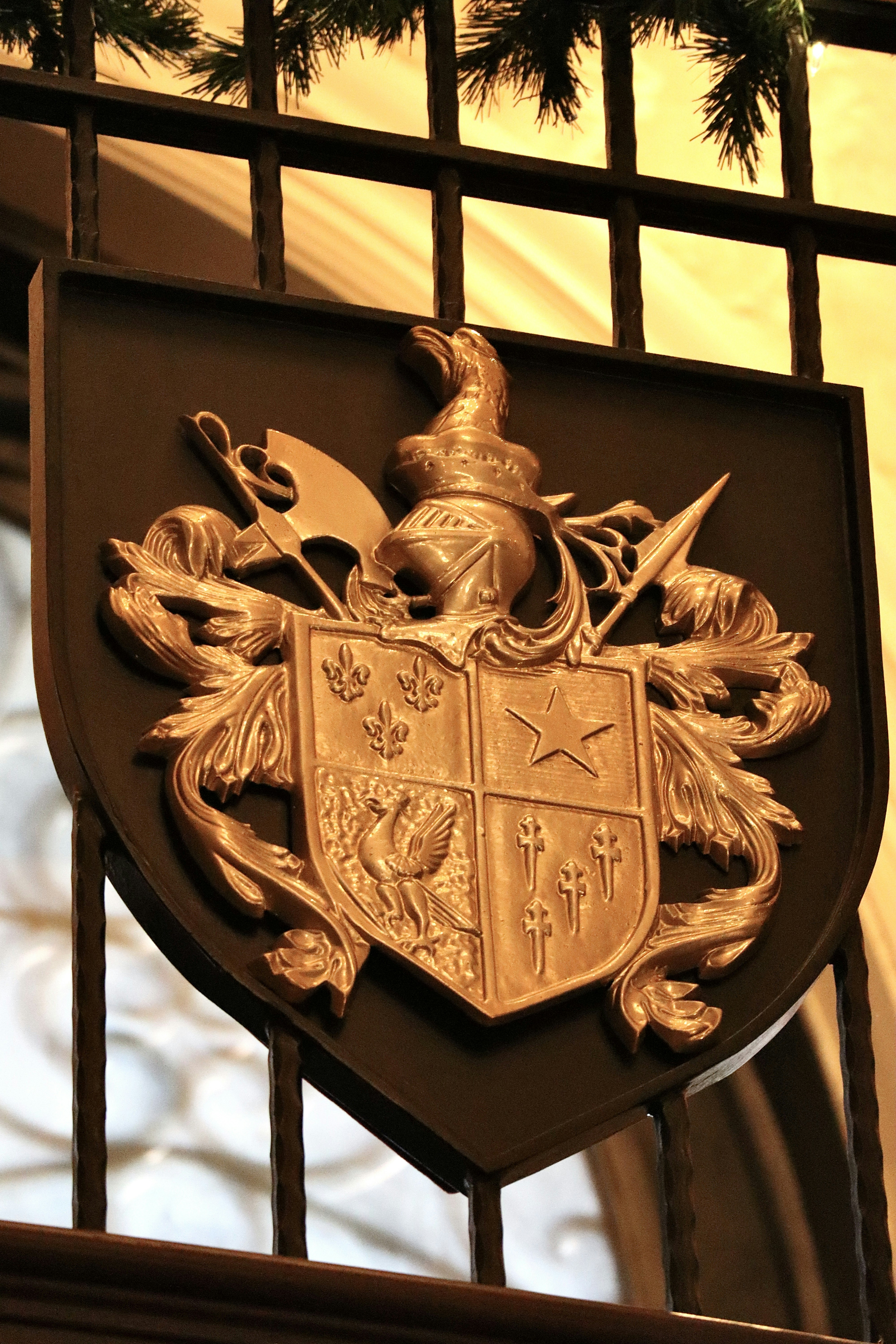 Guarded Crest: A Brass Herald Looms Behind Wrought Iron