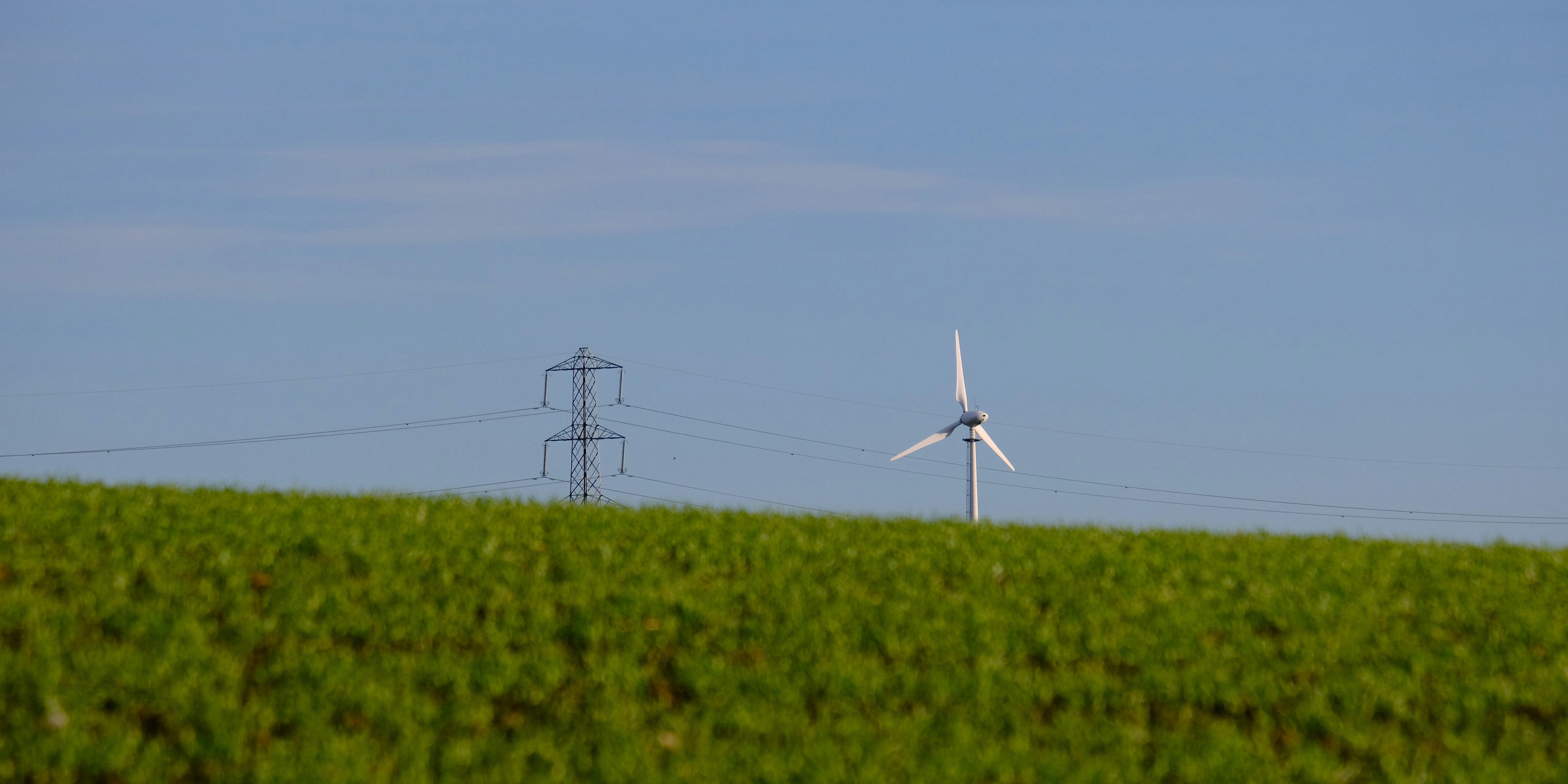 Wind Turbine on the Crest: A Quiet Vastness Over Green Fields