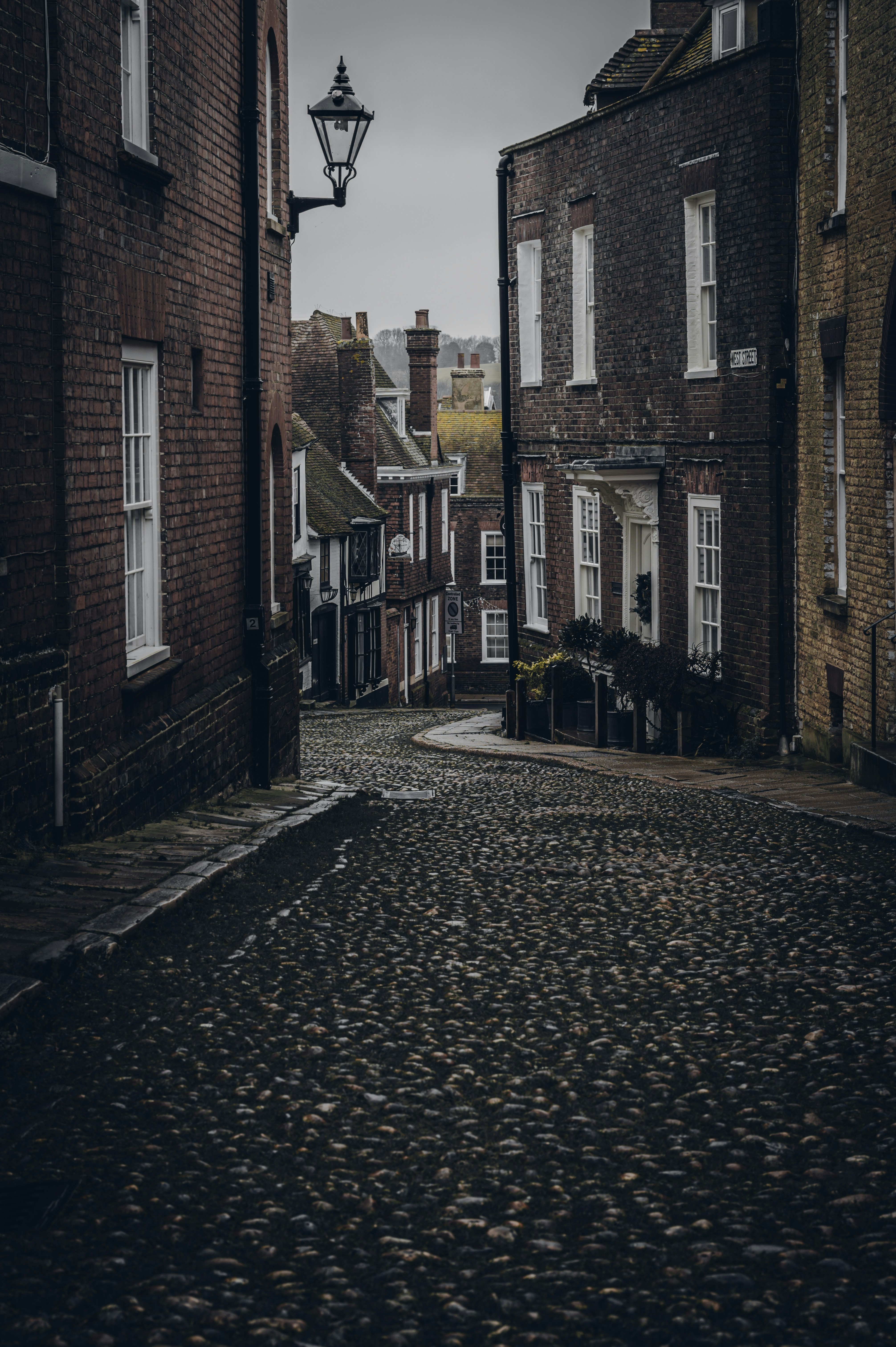 An old cobbled street in Rye. | a cobblestone street lined with brick buildings