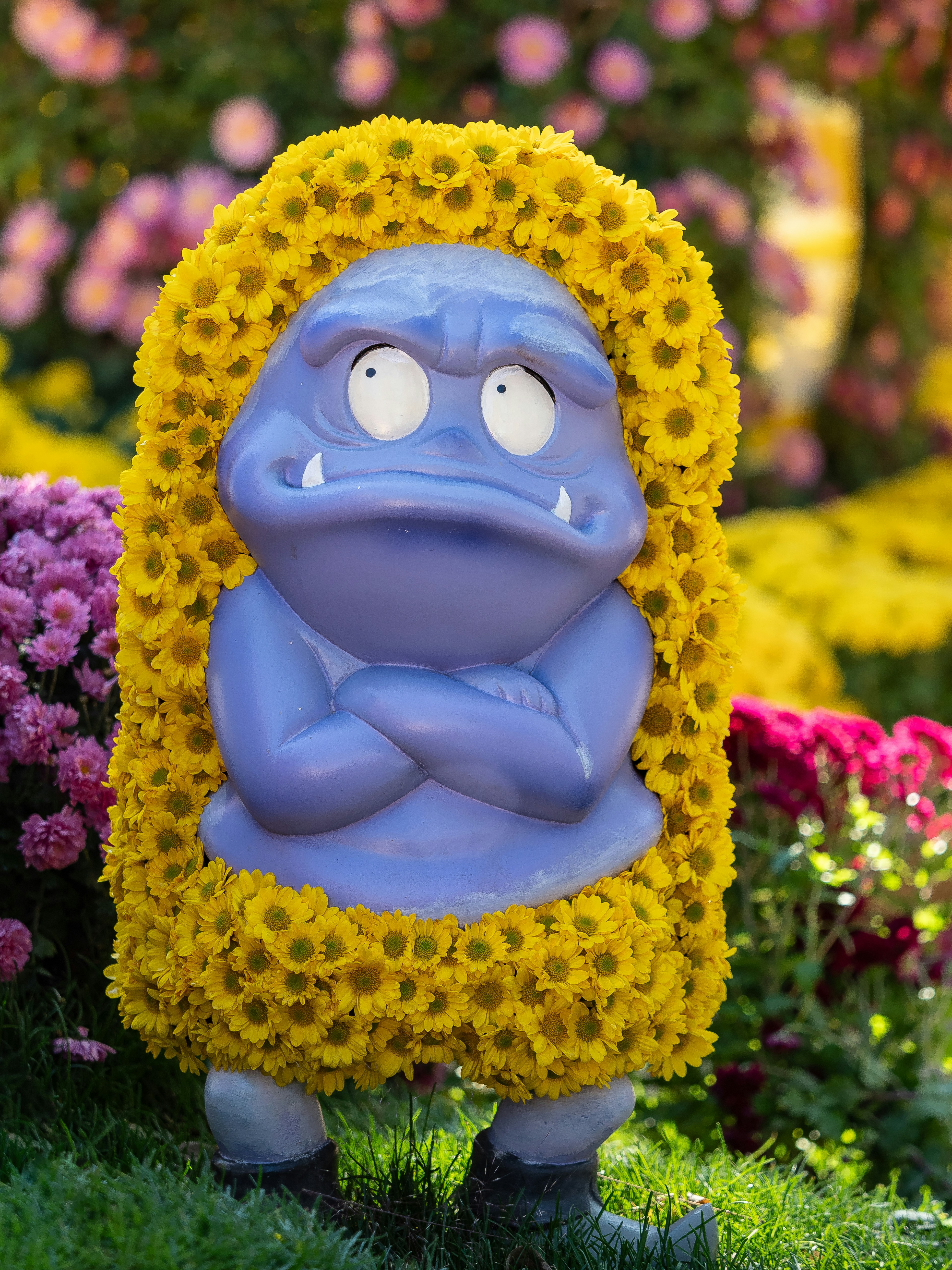 Blue Statue with Sunflower Garland in a Garden of Blooming Color