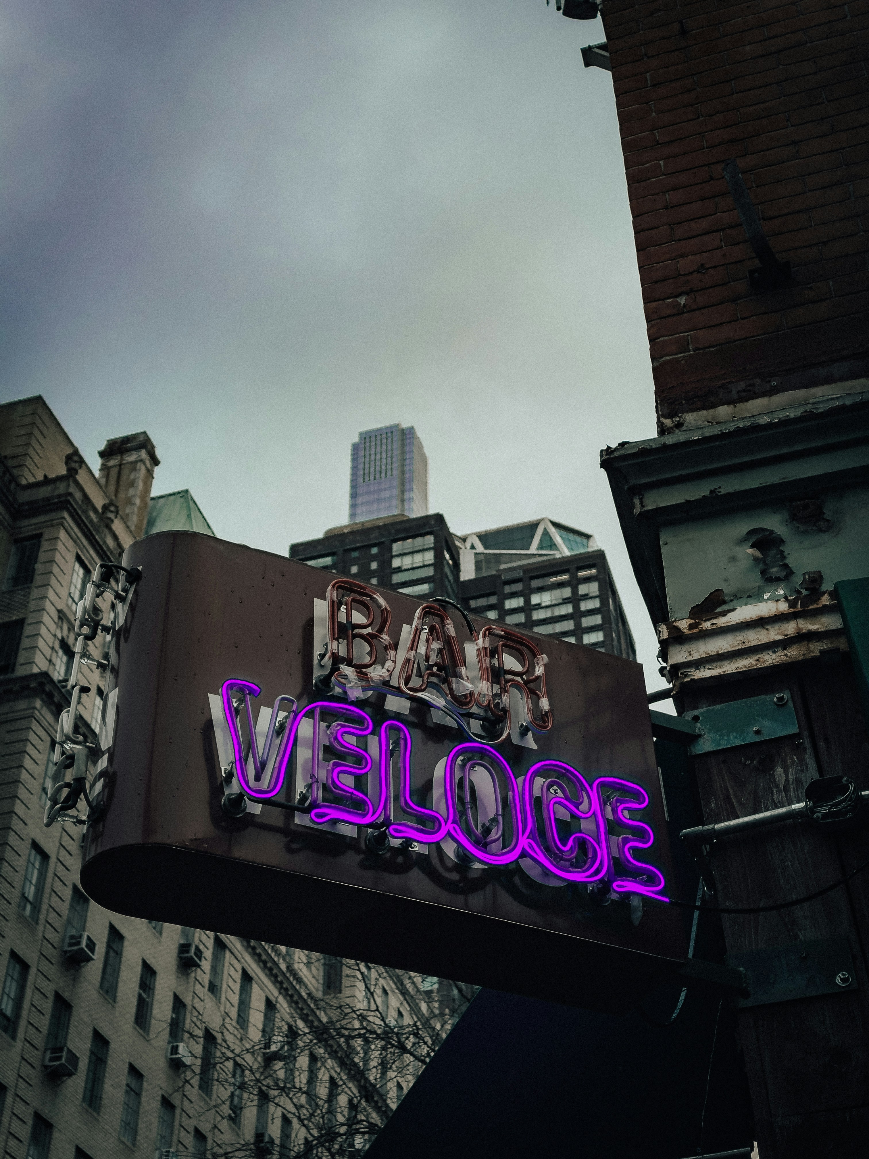 Une enseigne au néon violet qui se trouve sur le côté d’un bâtiment ...