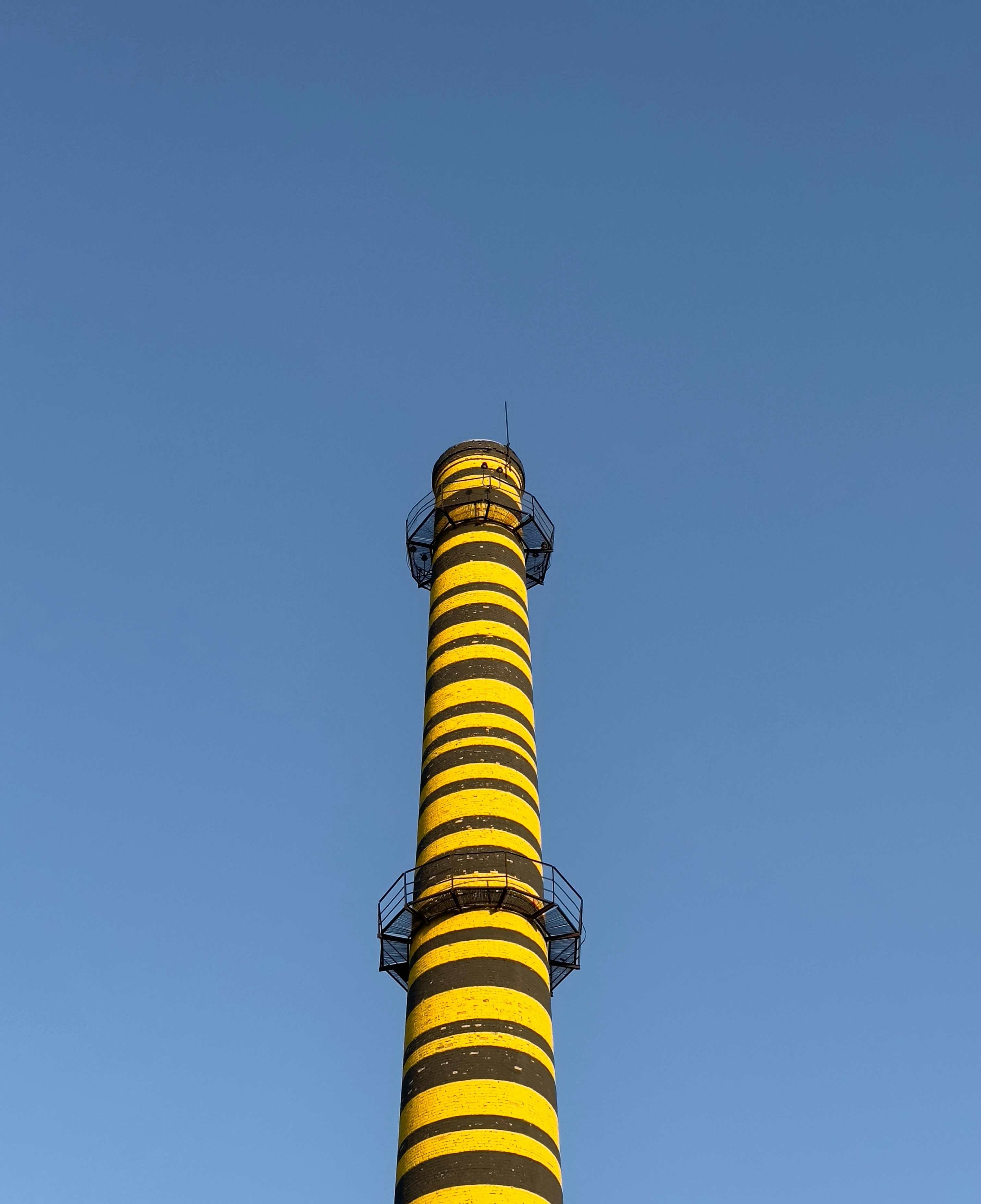 Striped Smokestack Rising into a Cerulean Sky