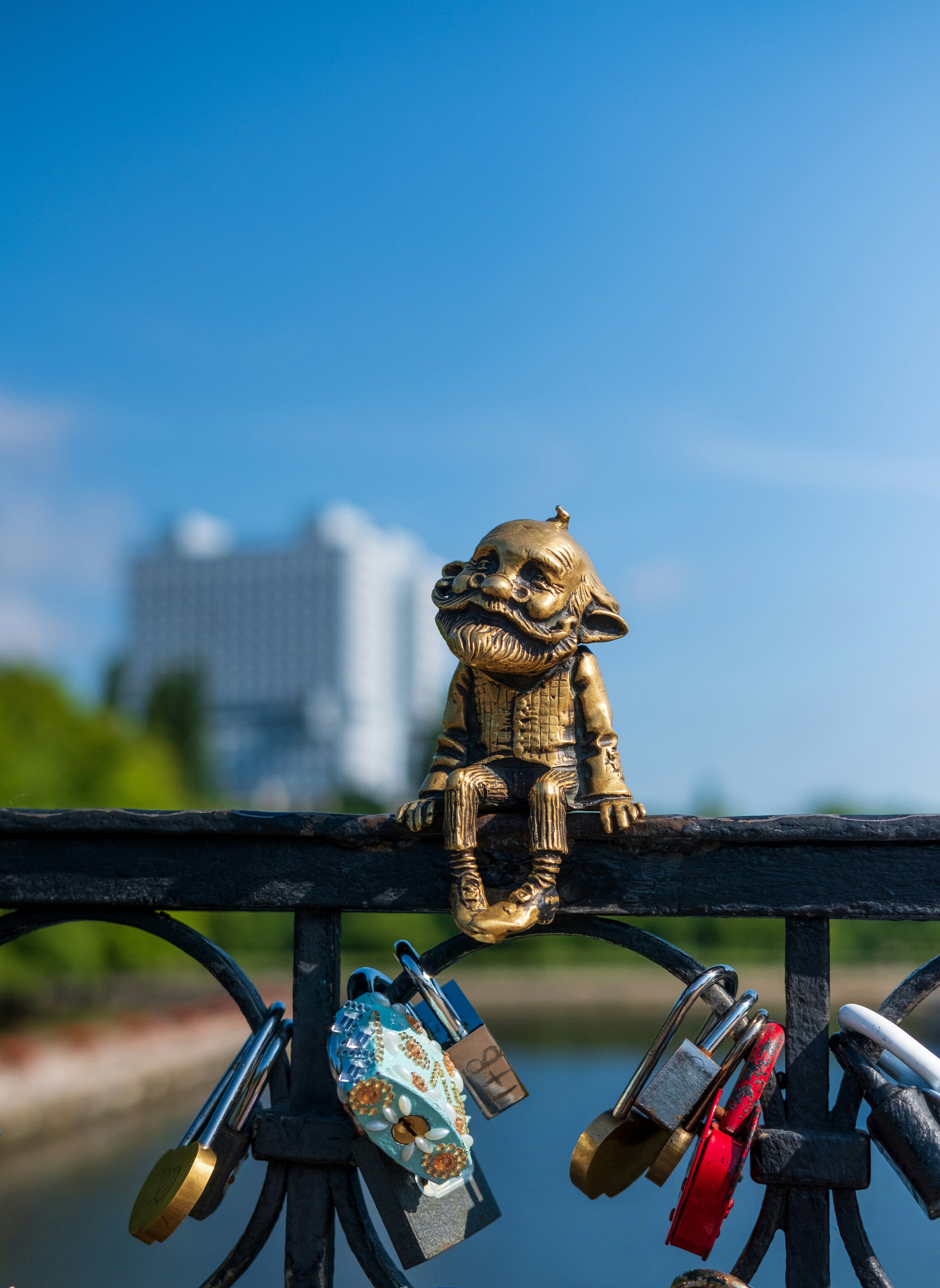 Bronze Goblin on a Railing of Locks Over a Quiet River