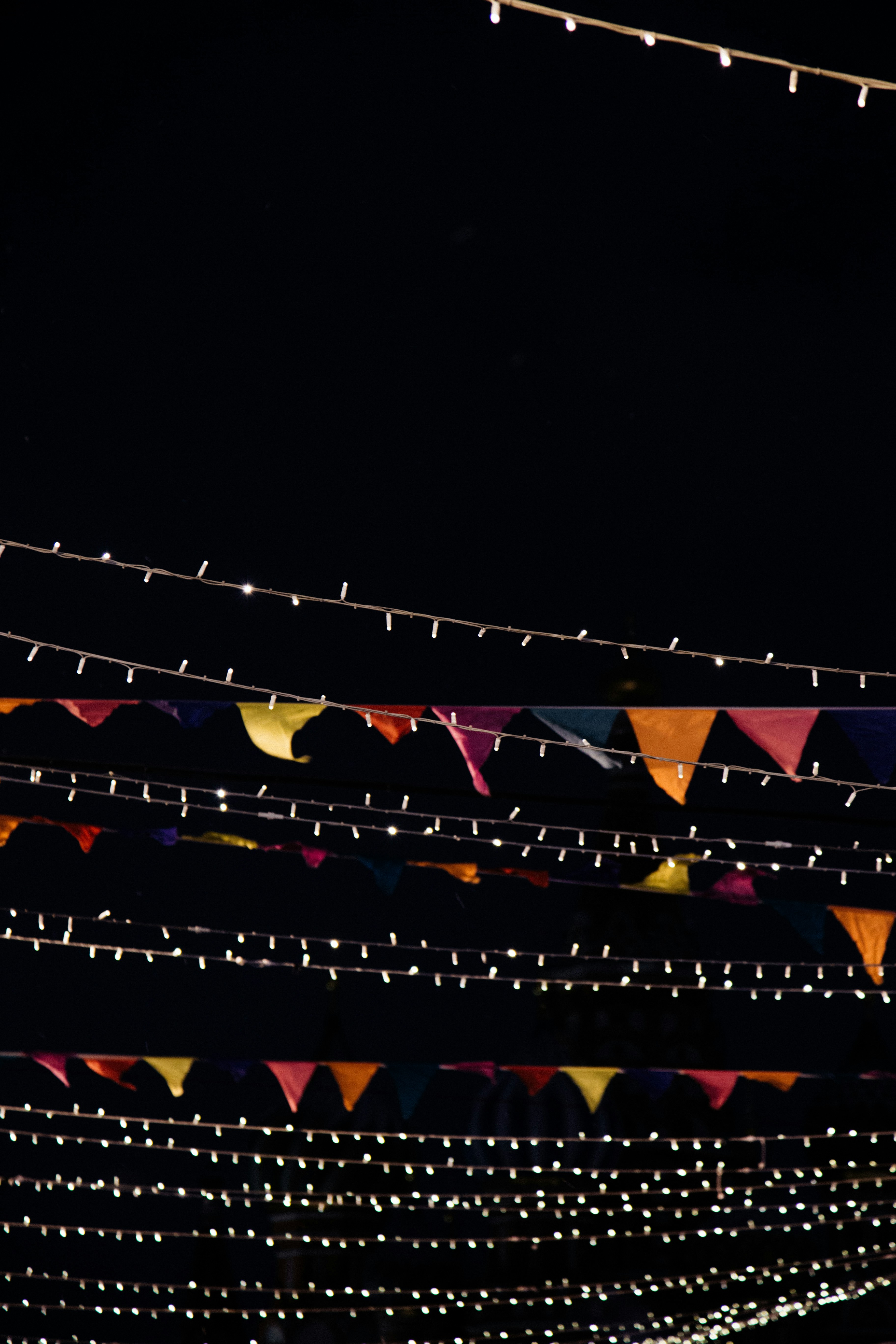 Moonlit Wirework: A Night of Festive Flags Under Gentle String Lights