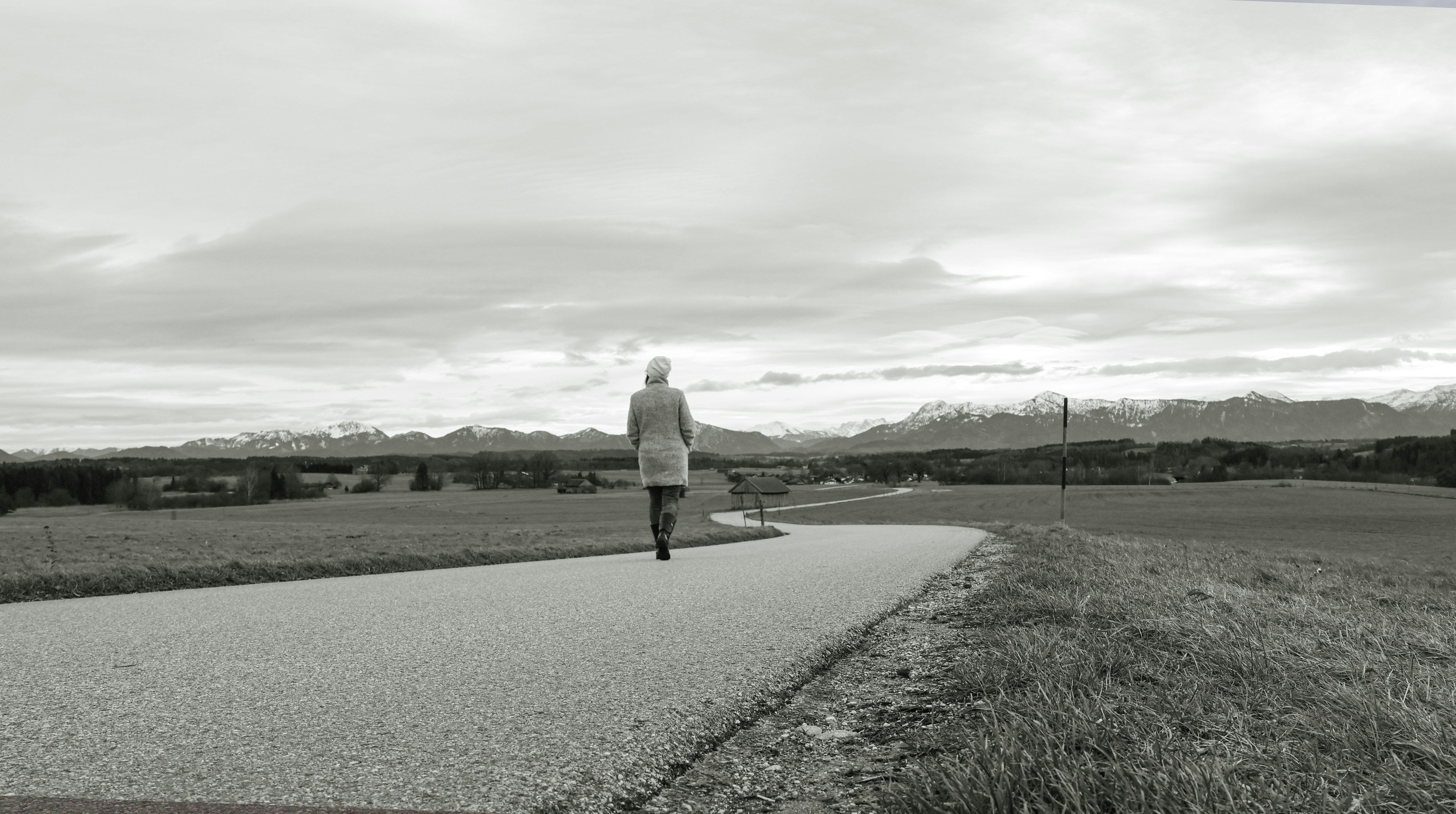 A person walking down a road in a black and white photo photo – Free ...