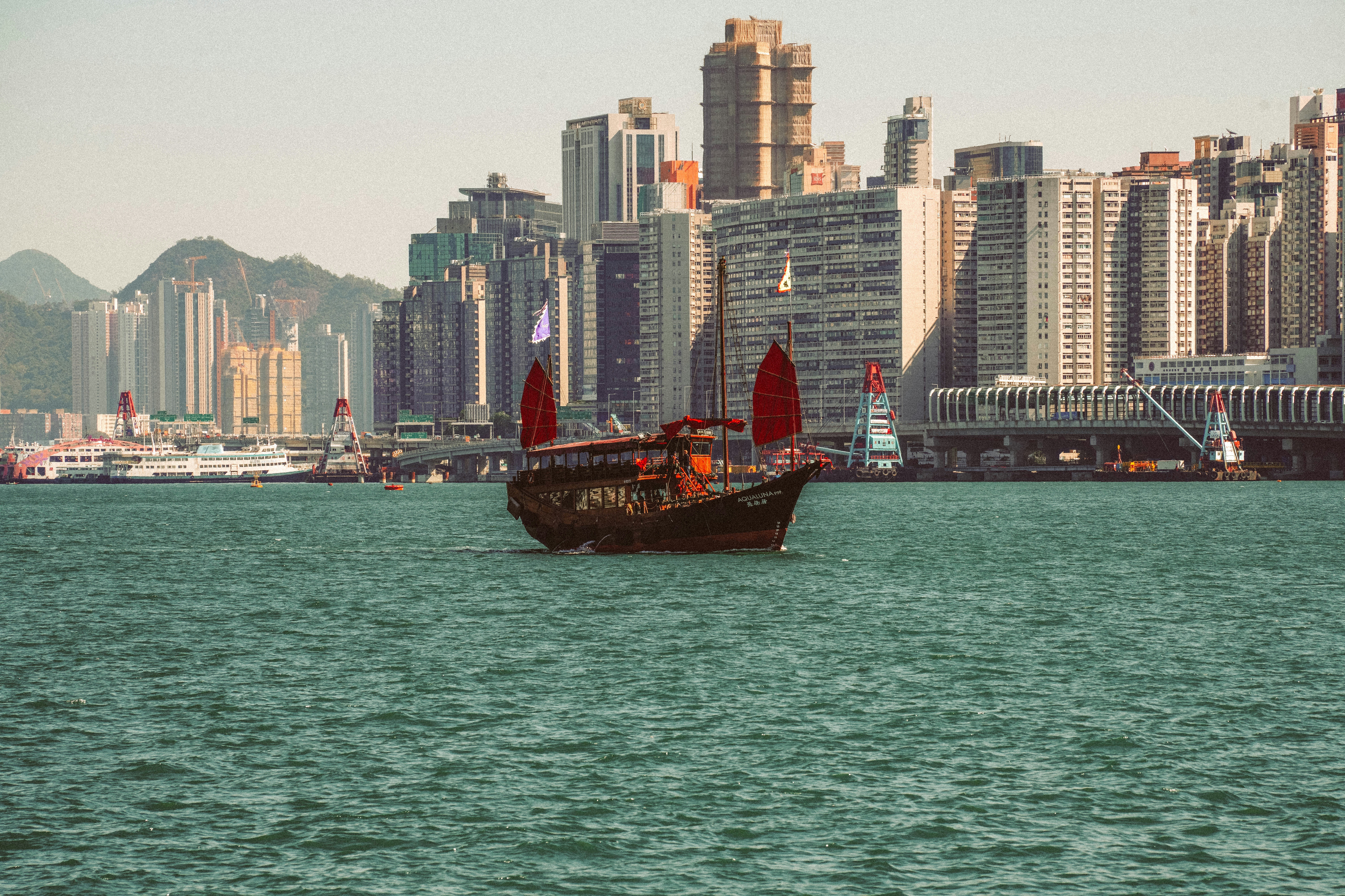 Sailboat against a coastal cityscape